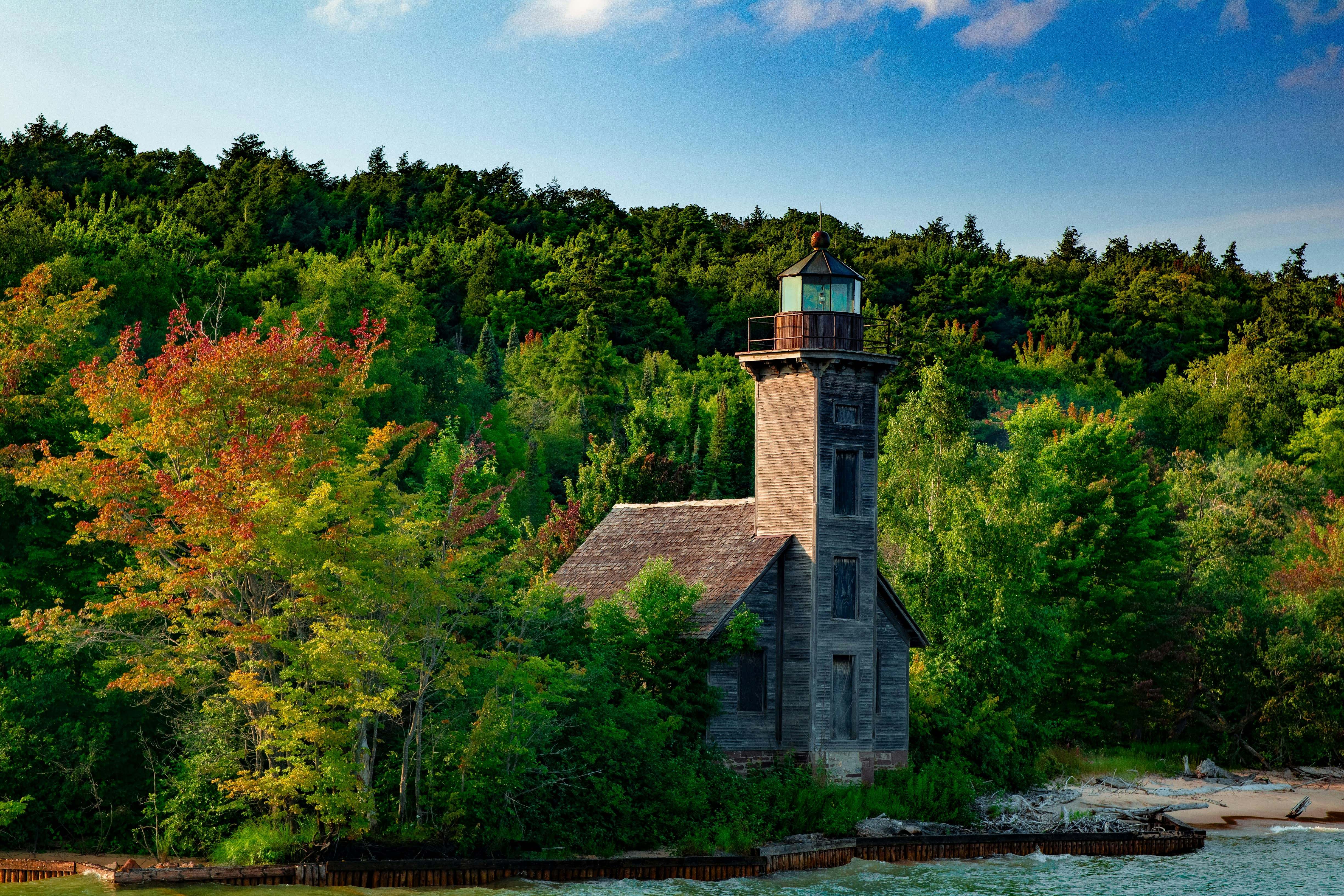 Ember-Leaf Beacon: A Stone Lighthouse Beside Autumn Waters