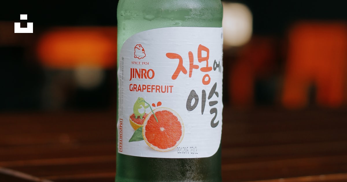 나무 테이블 위에 앉아 있는 녹색 액체 한 병 사진 Unsplash의 무료 위해서 이미지