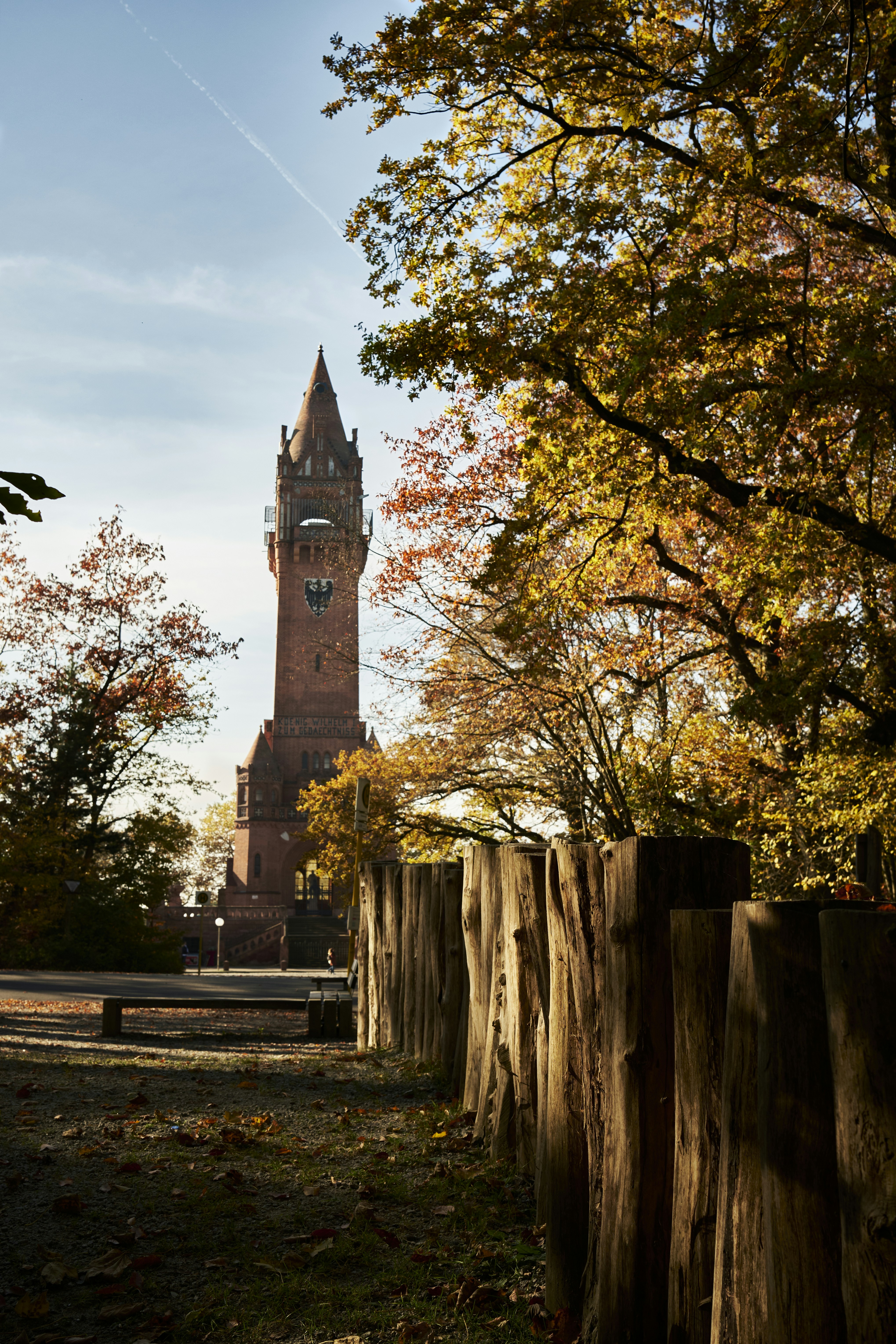 Silhouetted architecture against evening sky, autumn foliage, historical cityscape.