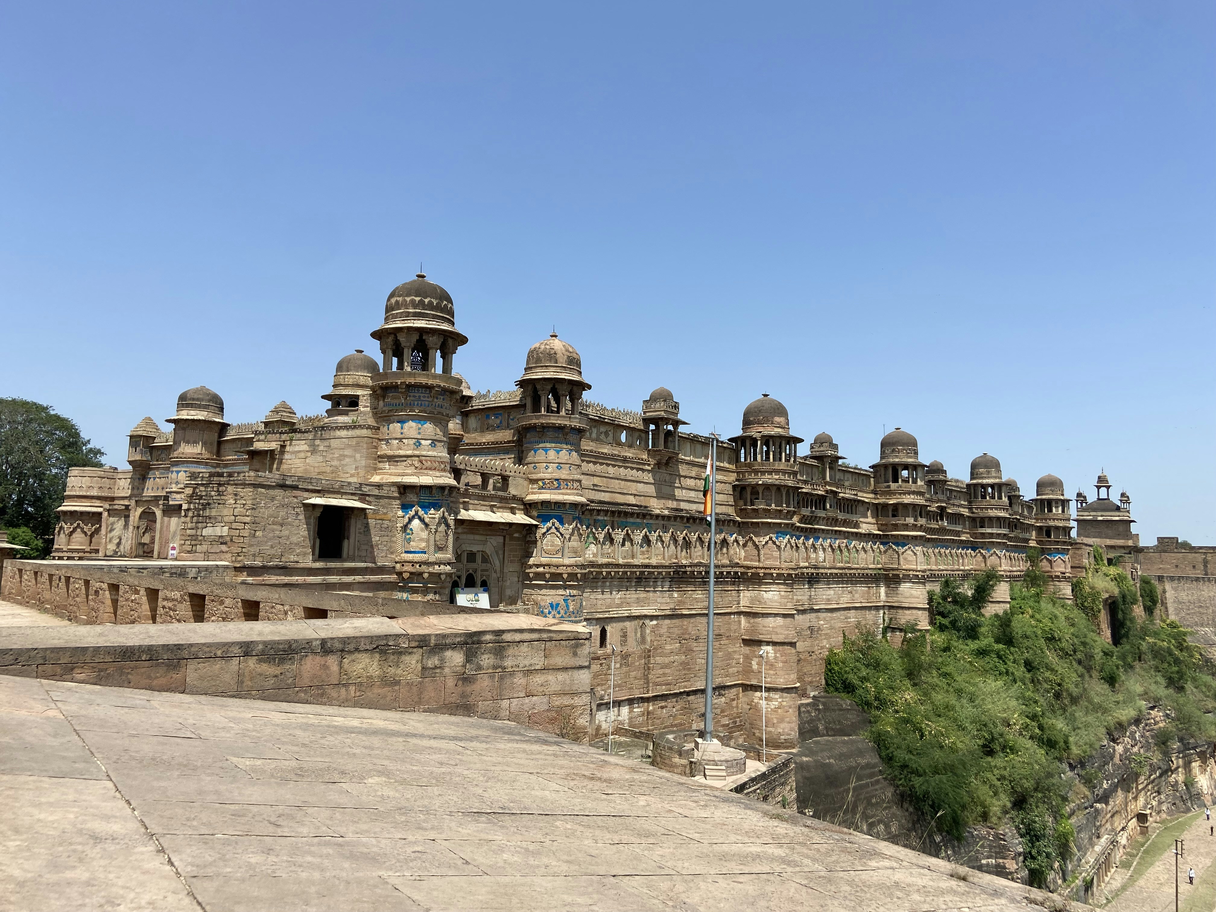 Historic fort with ornate domes and intricate stonework stretching under a bright blue sky.
