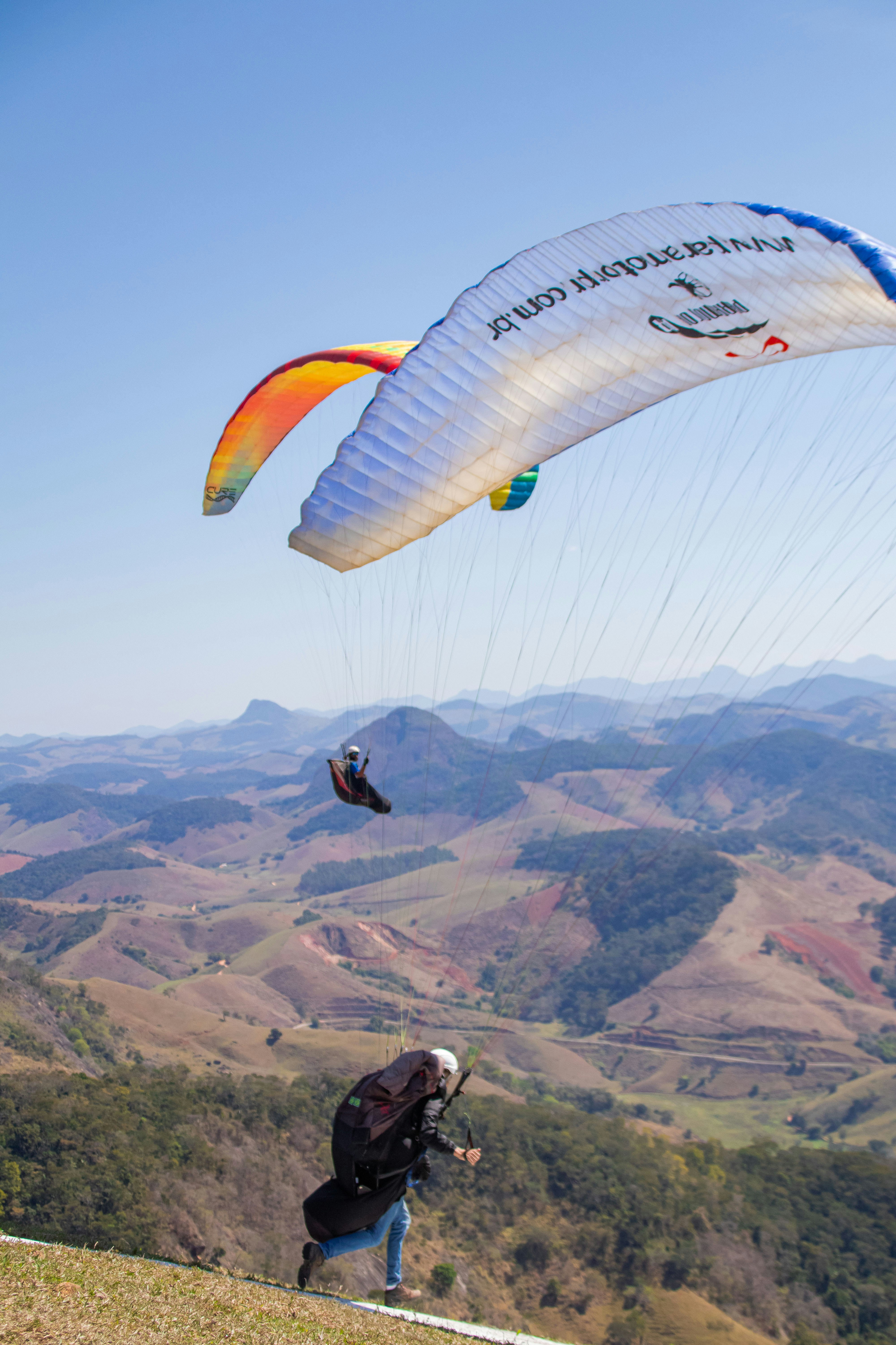 Un homme faisant voler un grand cerf-volant au-dessus d’une colline ...