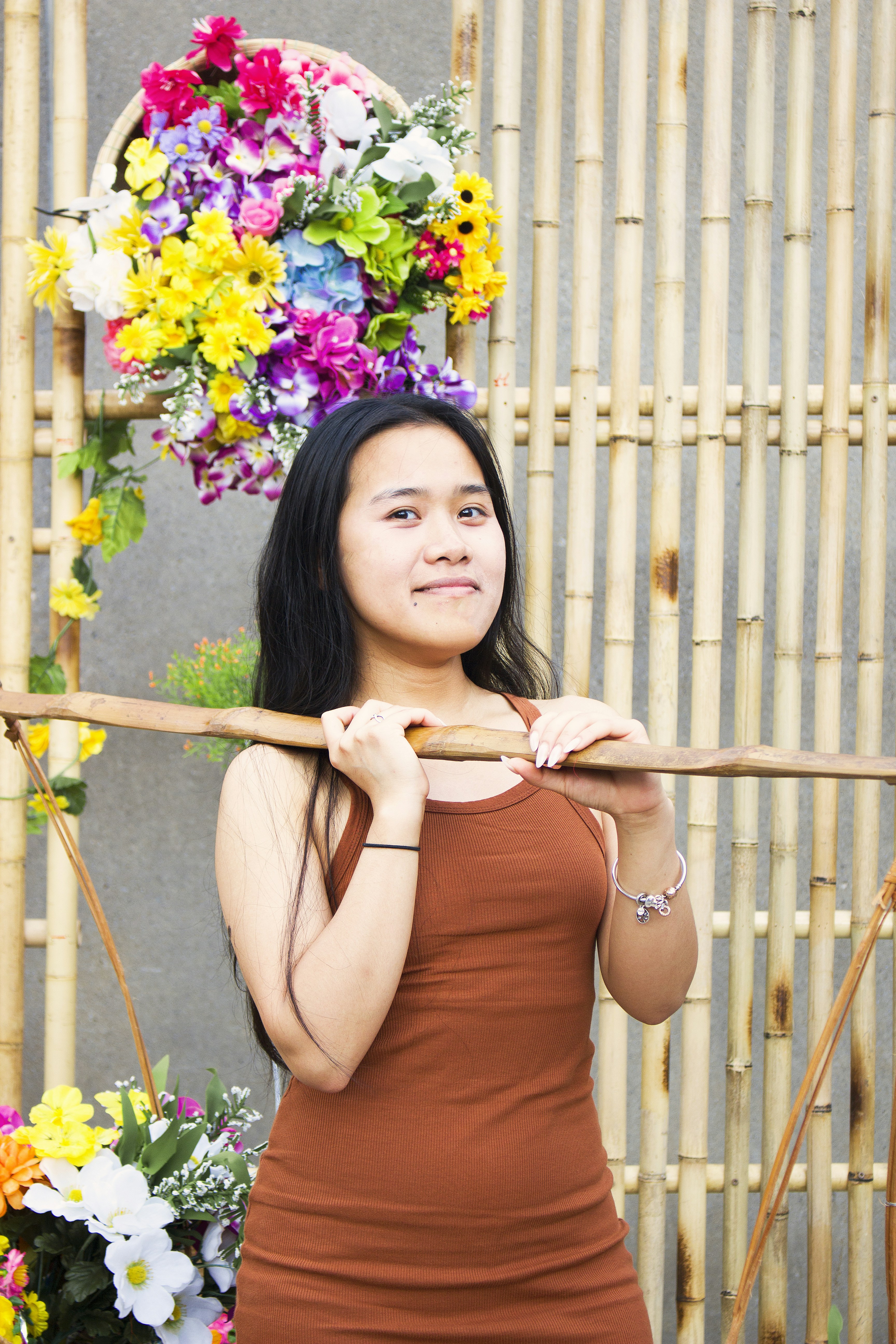 Portrait Under a Floral Cascade: Calm Confidence Before a Bamboo Backdrop