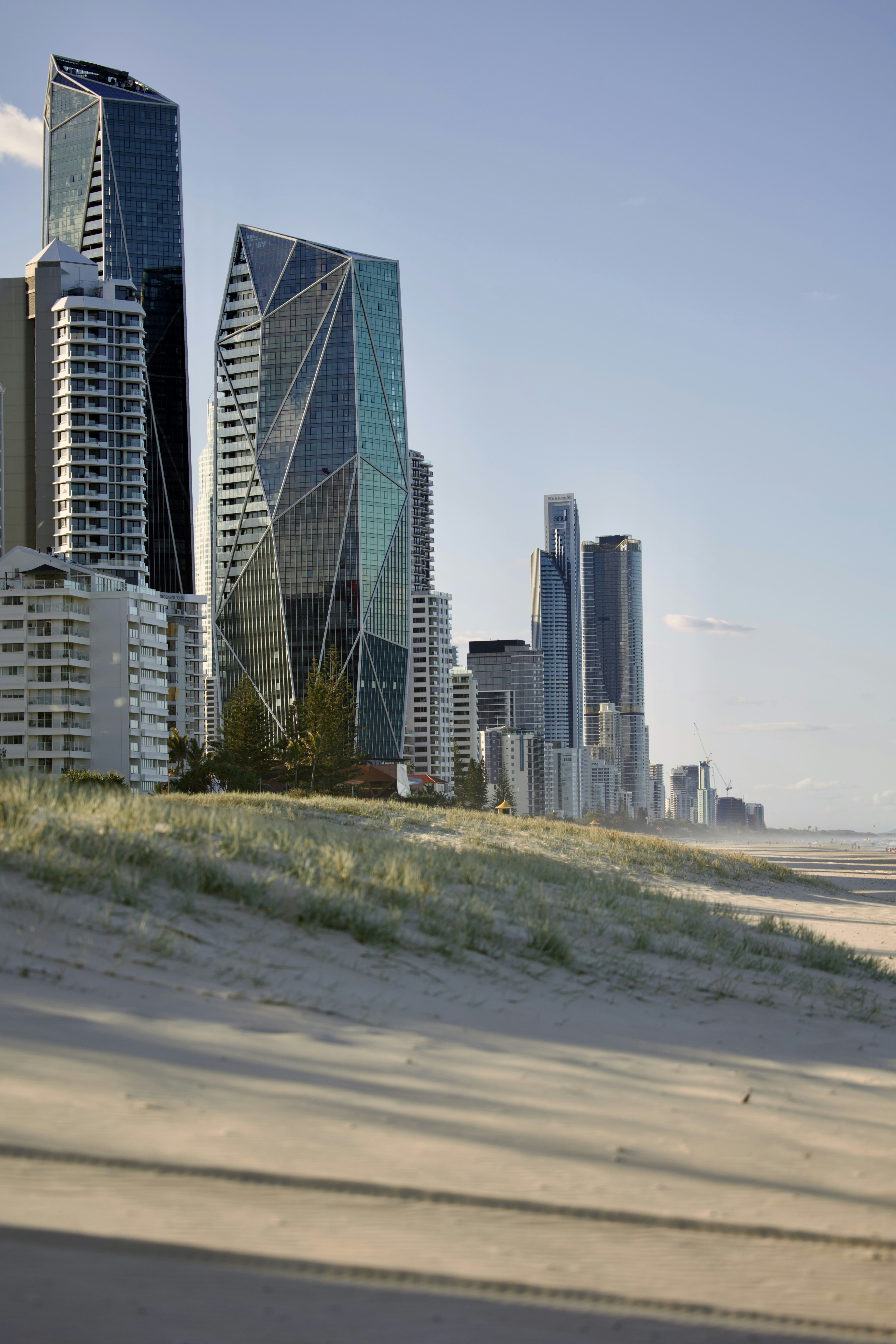 Angular Glass Coast: Skyscrapers Rise Over Quiet Dunes