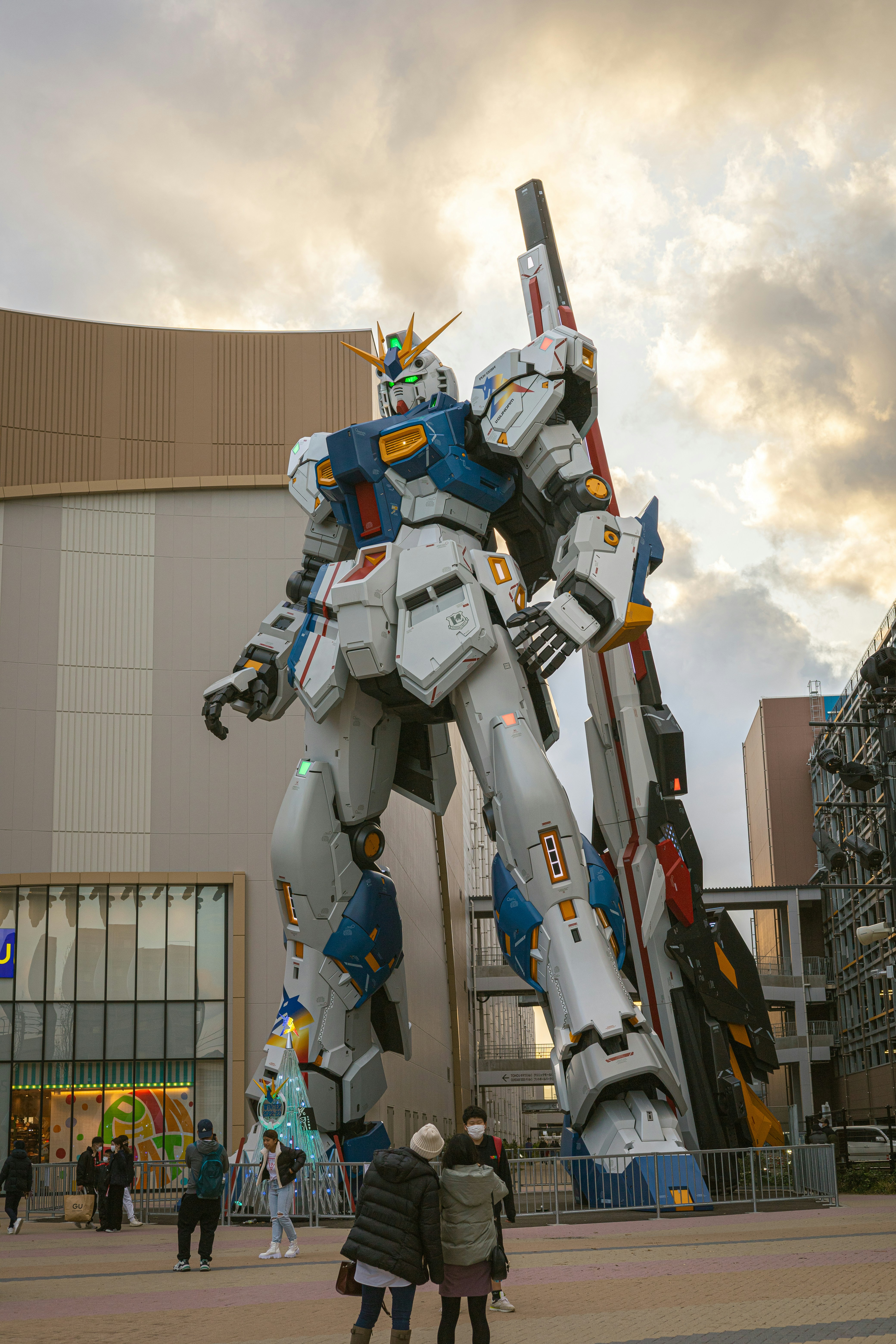 A giant robot standing next to a tall building photo – Free Lalaport ...