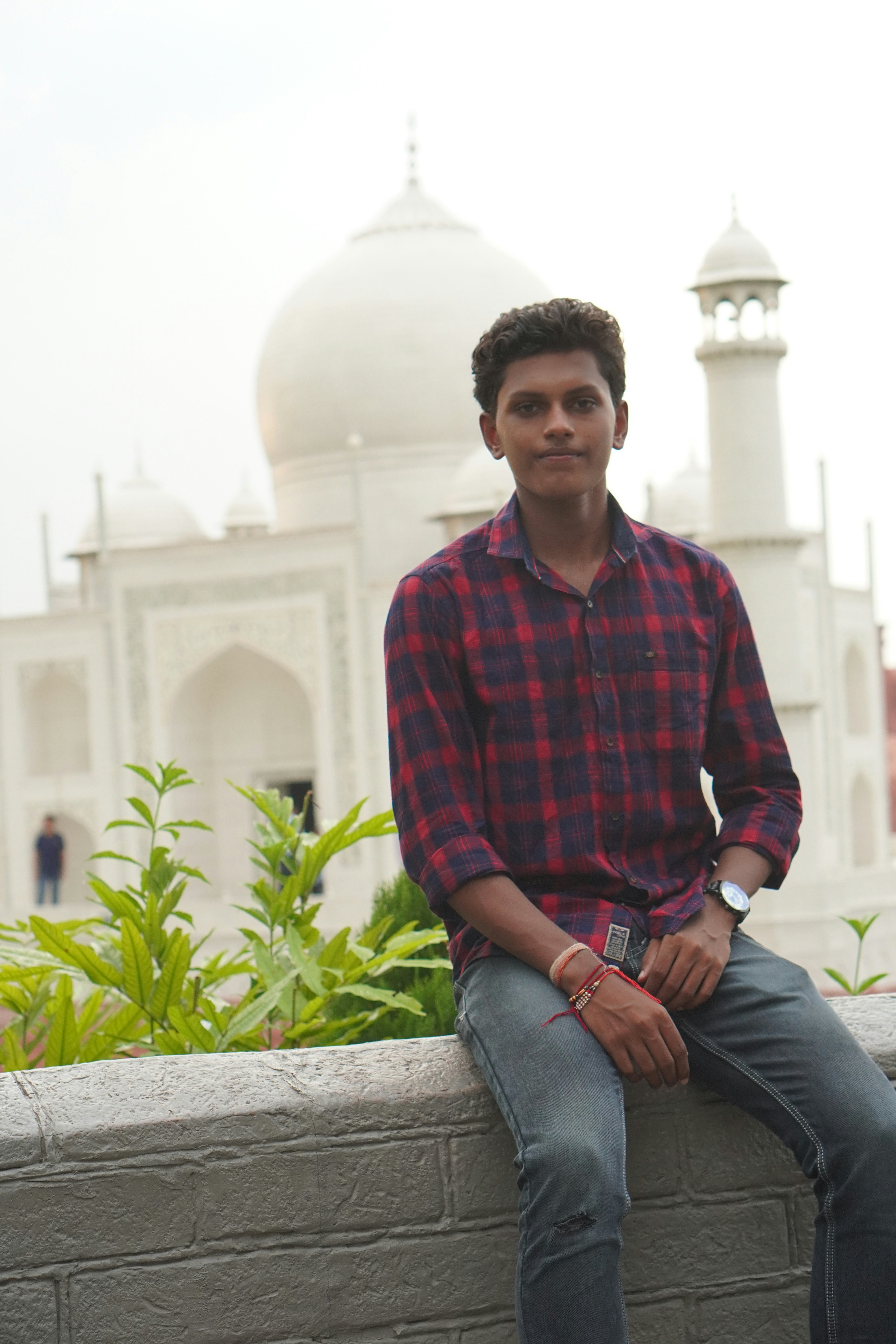 Un homme assis sur un mur devant un immeuble photo – Photo Eco Parc ...