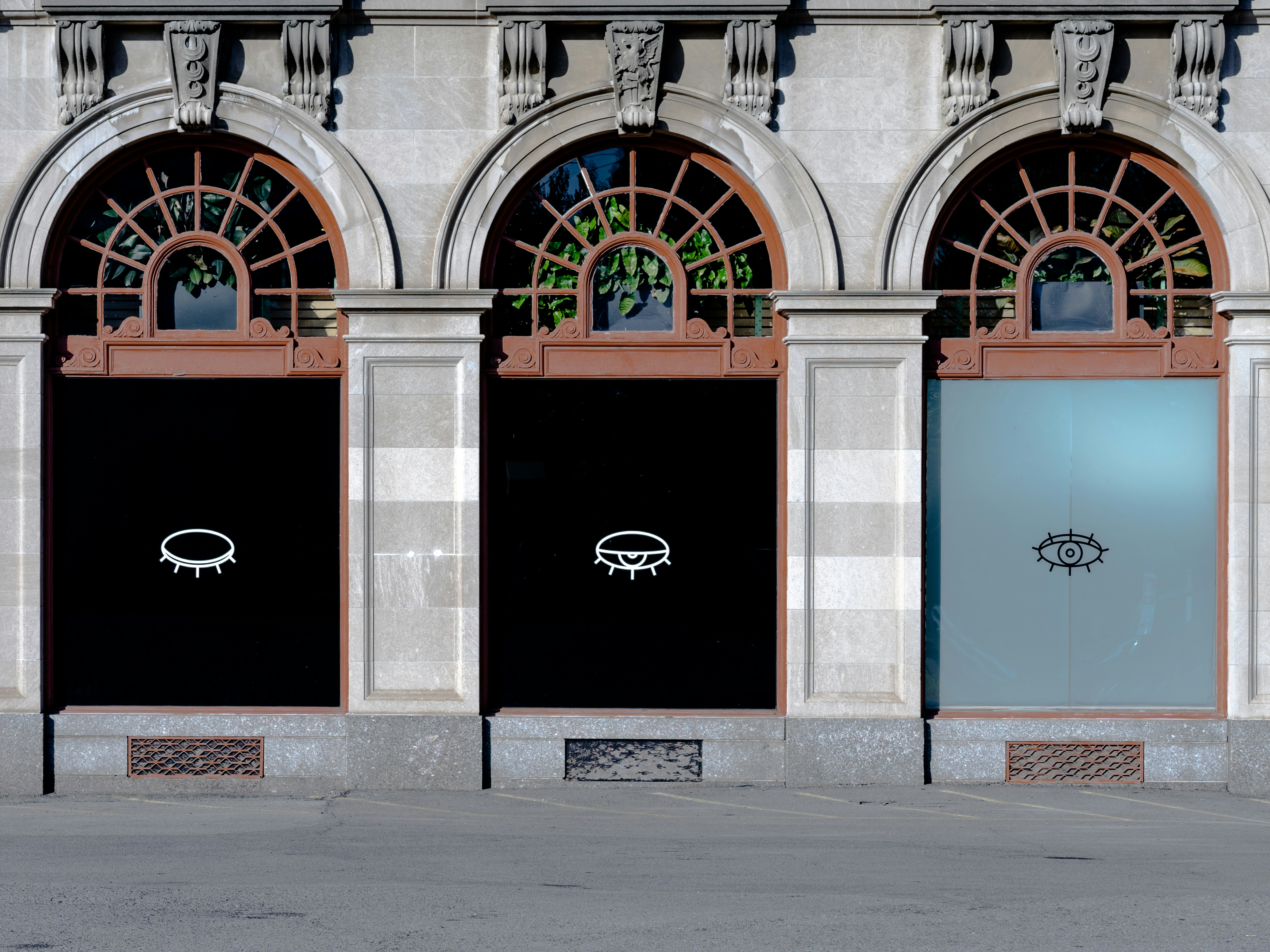 Symmetry in Stone: White Circular Logos Anchor a Trio of Arches