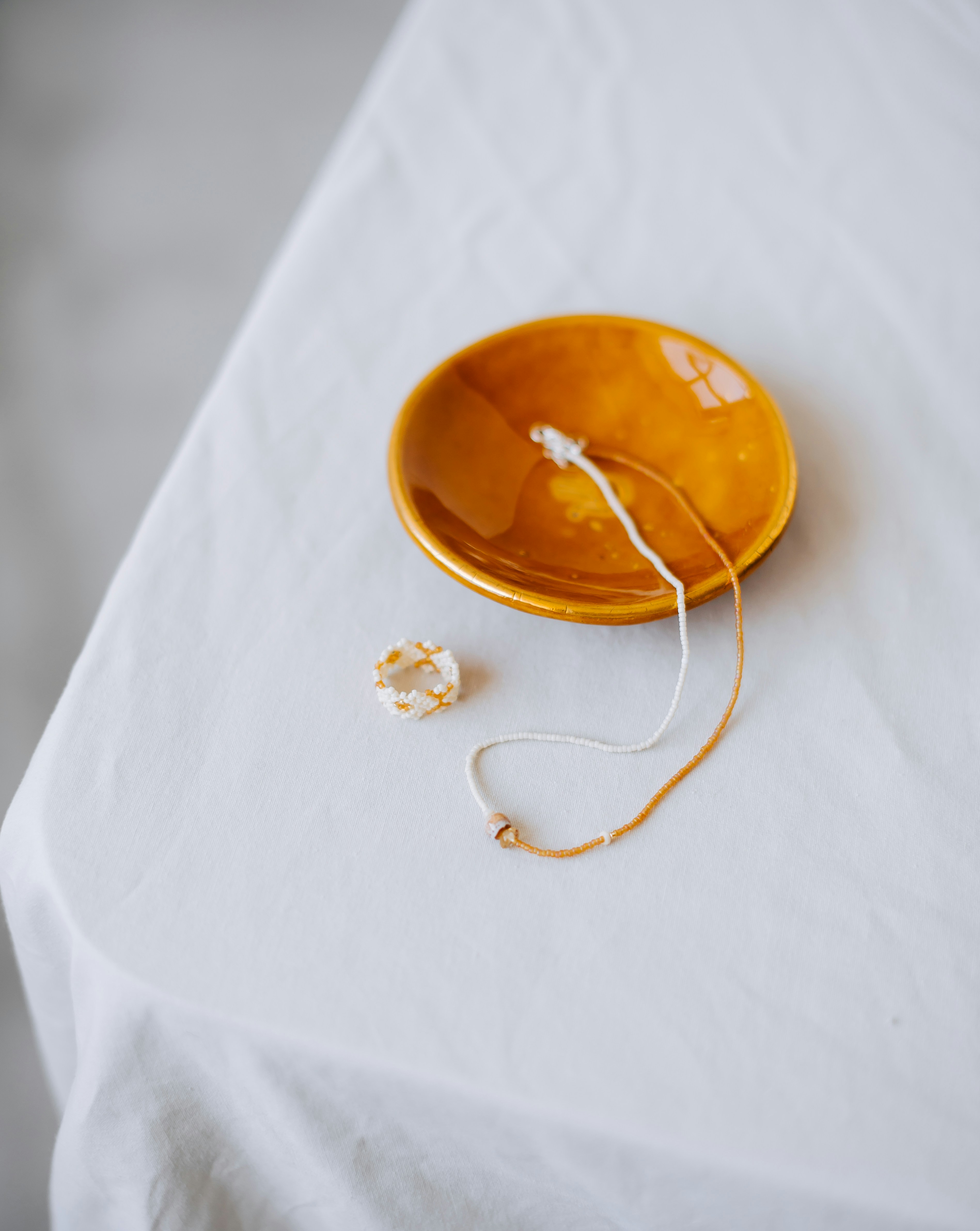 Amber Dish on a White Table: A Minimal Still-Life of Thread and Light