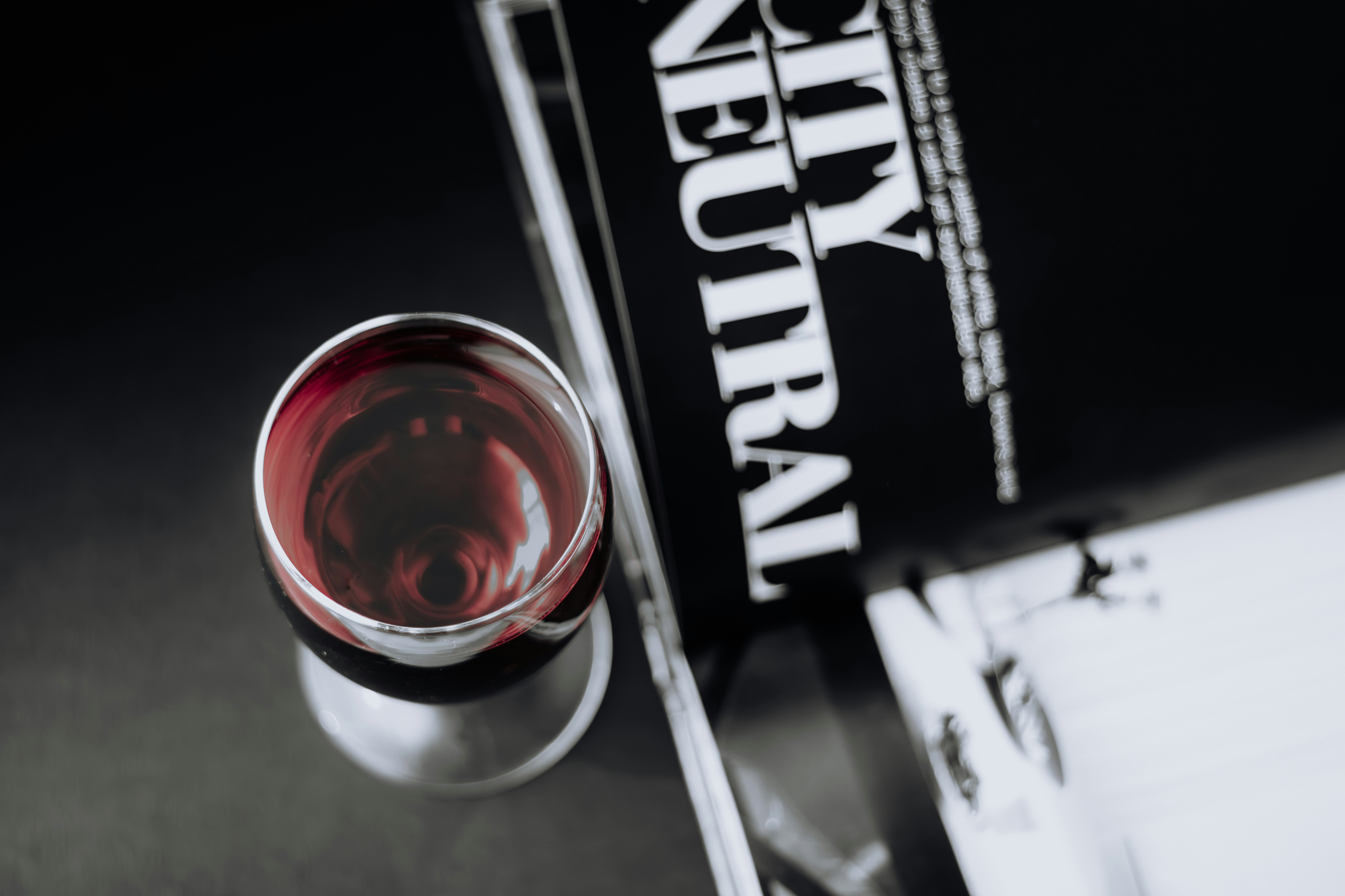 Crimson Glass on a Tilted Page: A Quiet Still Life