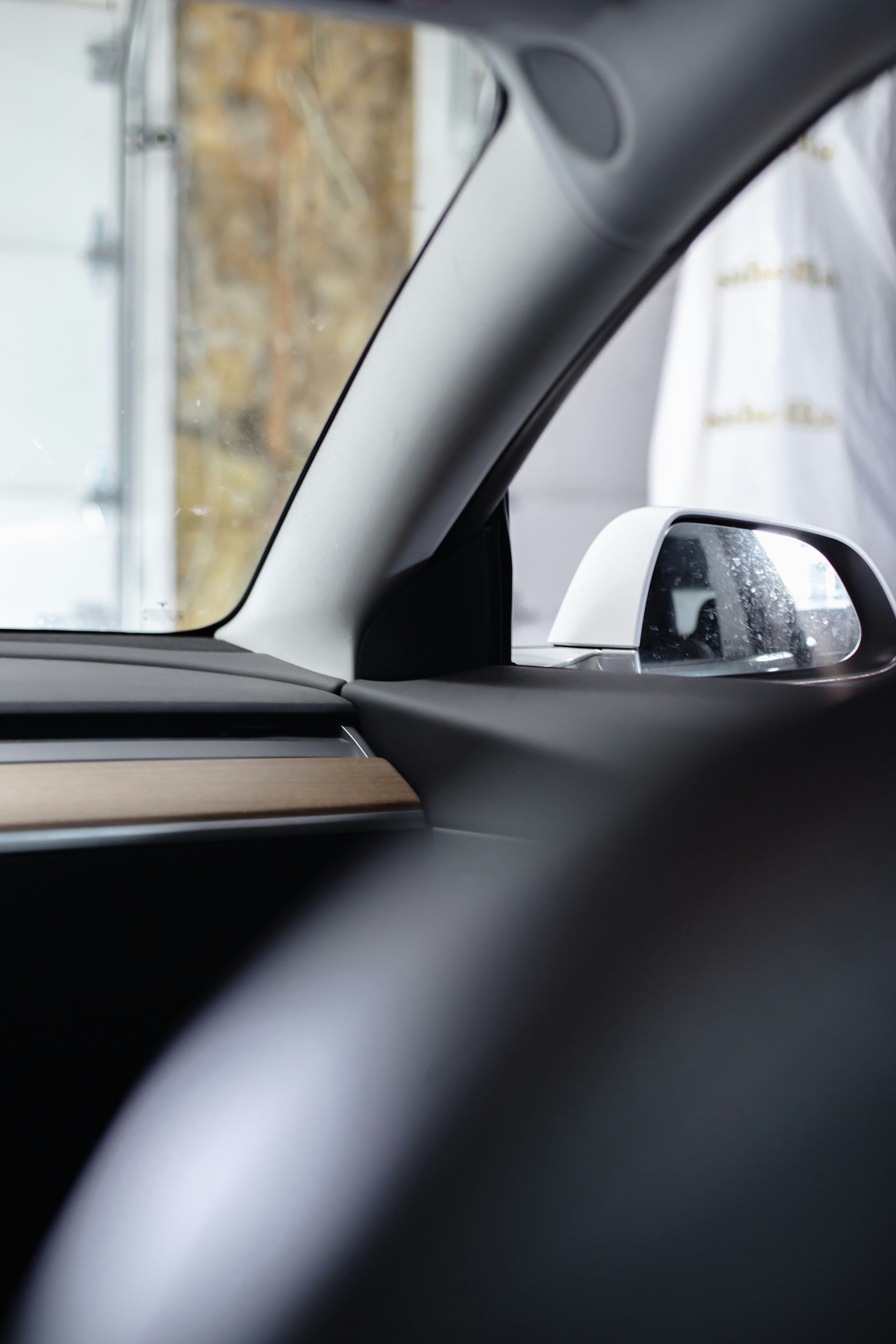 Glass and Grain: Inside the Car Framed by a Rain-Dusted Side Mirror