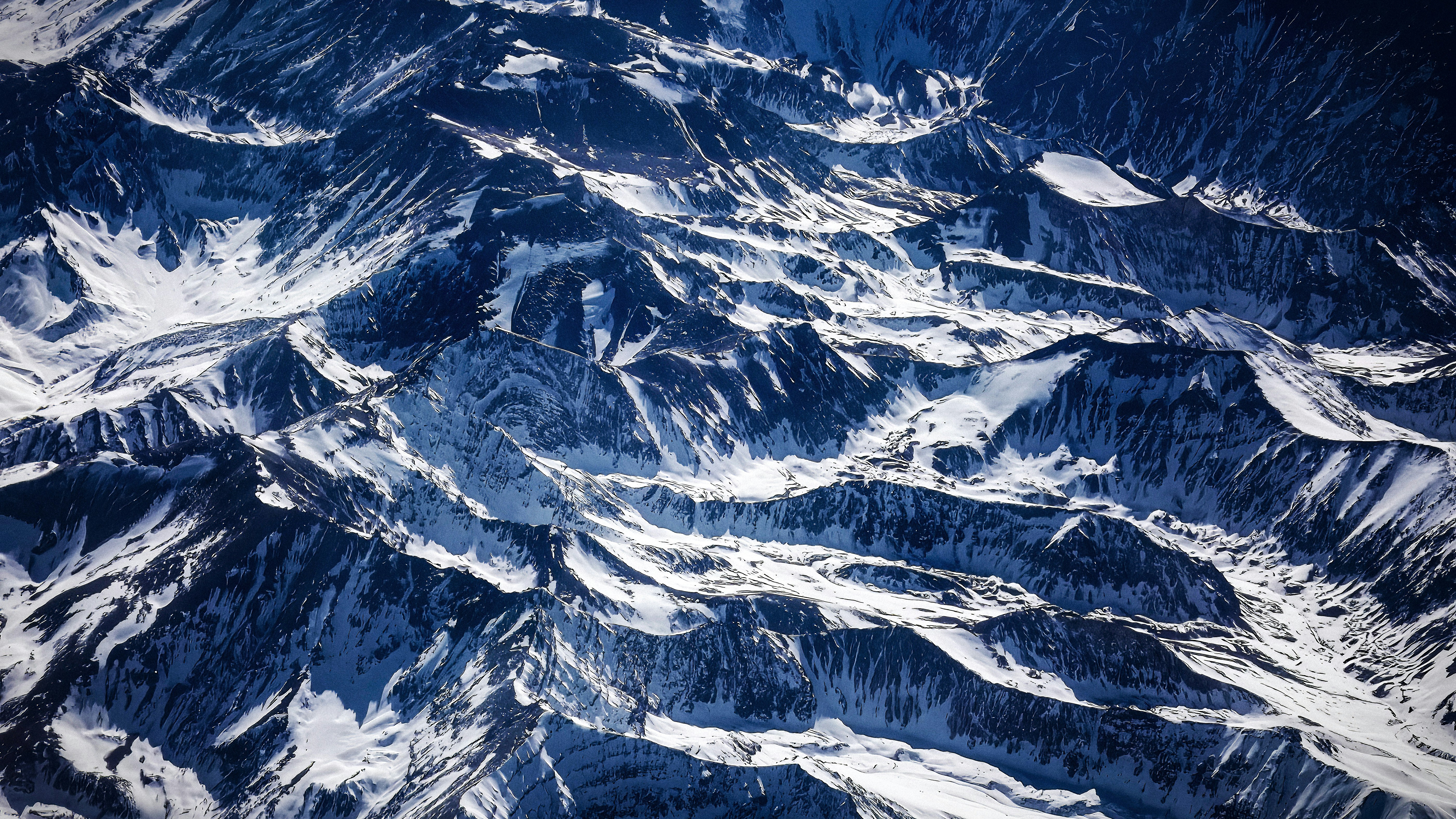 An aerial view of a snow covered mountain range photo – Free Snow Image ...