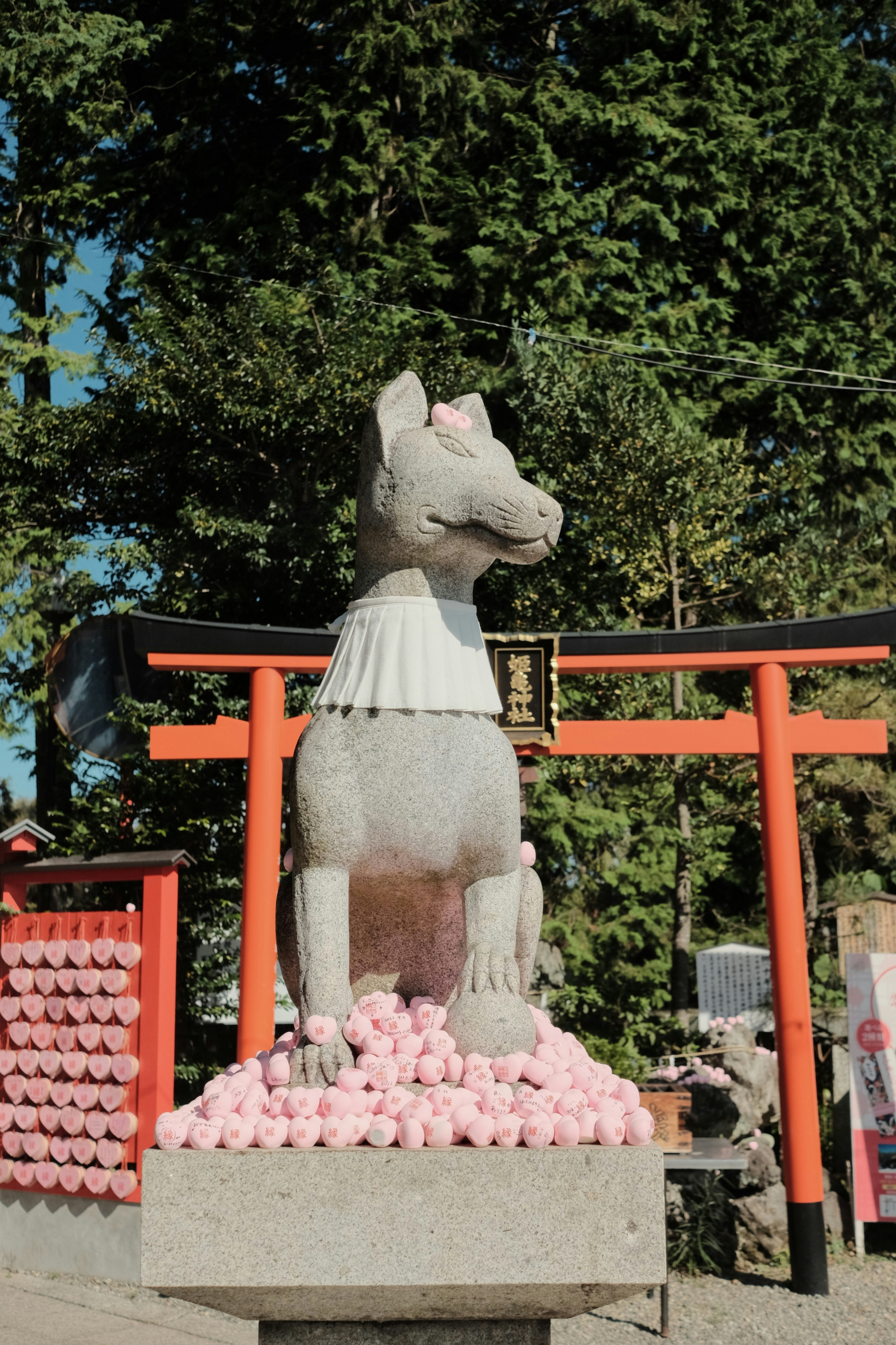 A statue of a dog with pink balls in front of it photo – Free Shrine ...