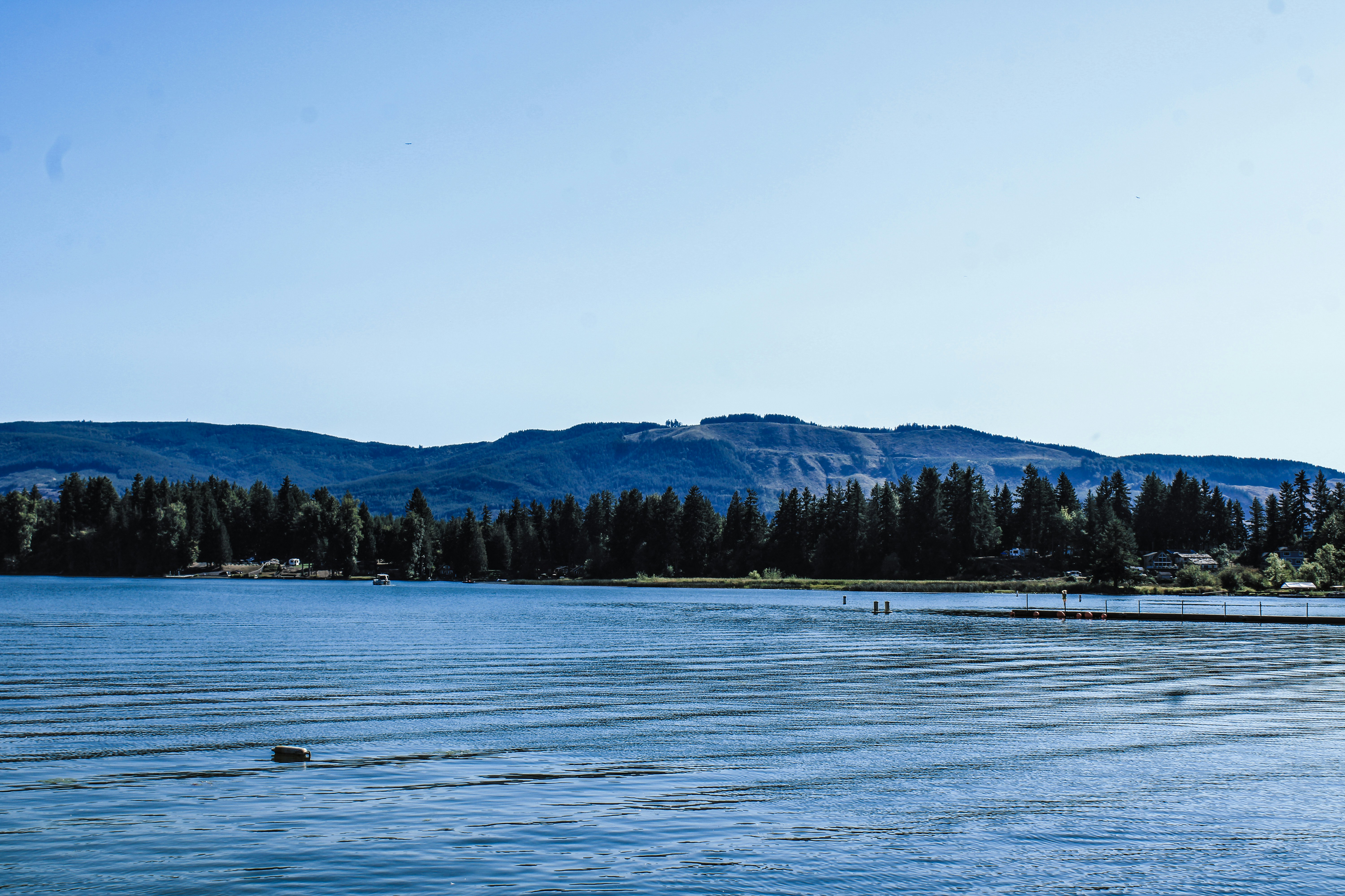 A large body of water with a mountain in the background photo – Free ...