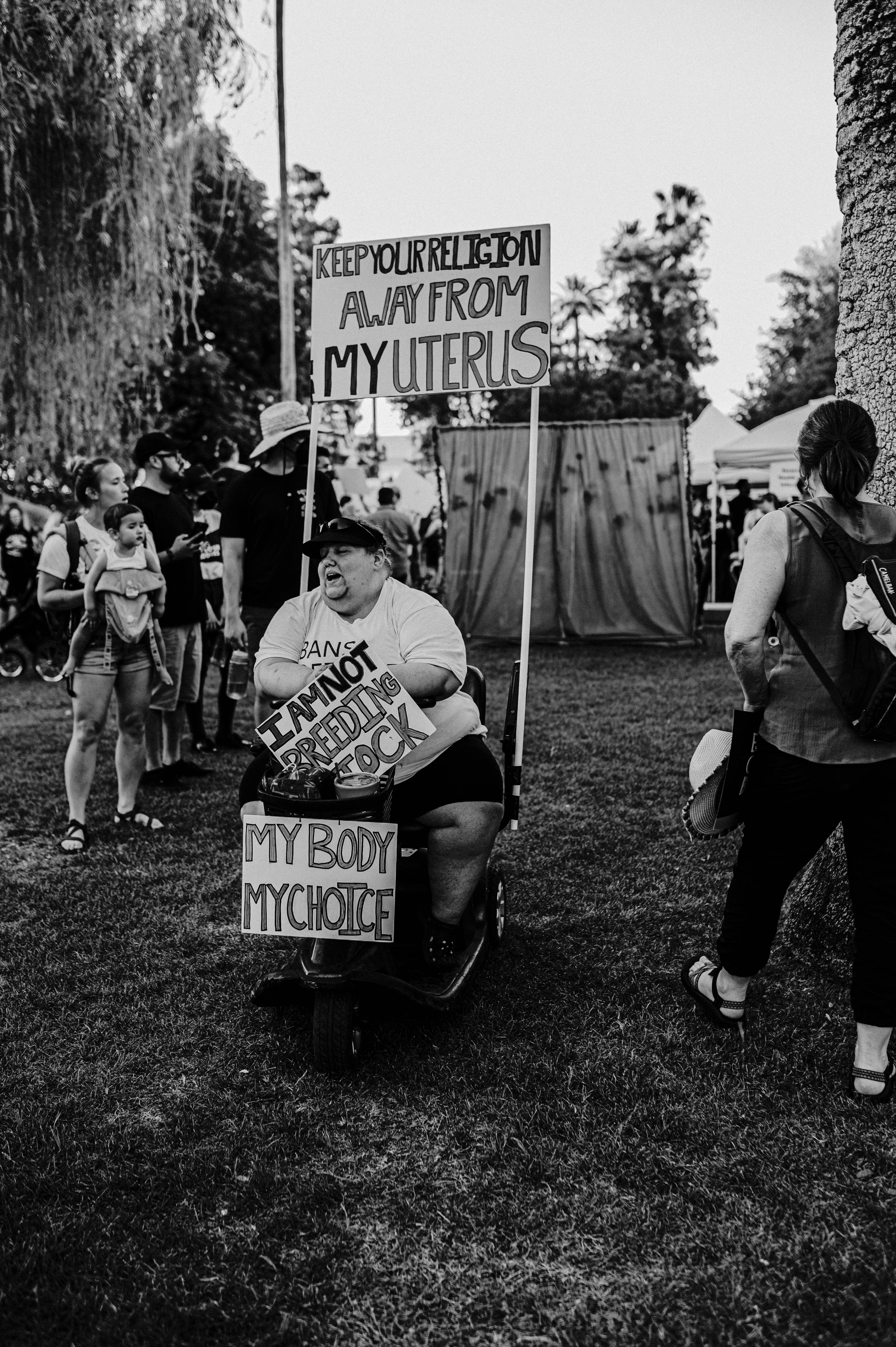 A woman sitting in a wheel chair holding a sign photo – Free Protest ...