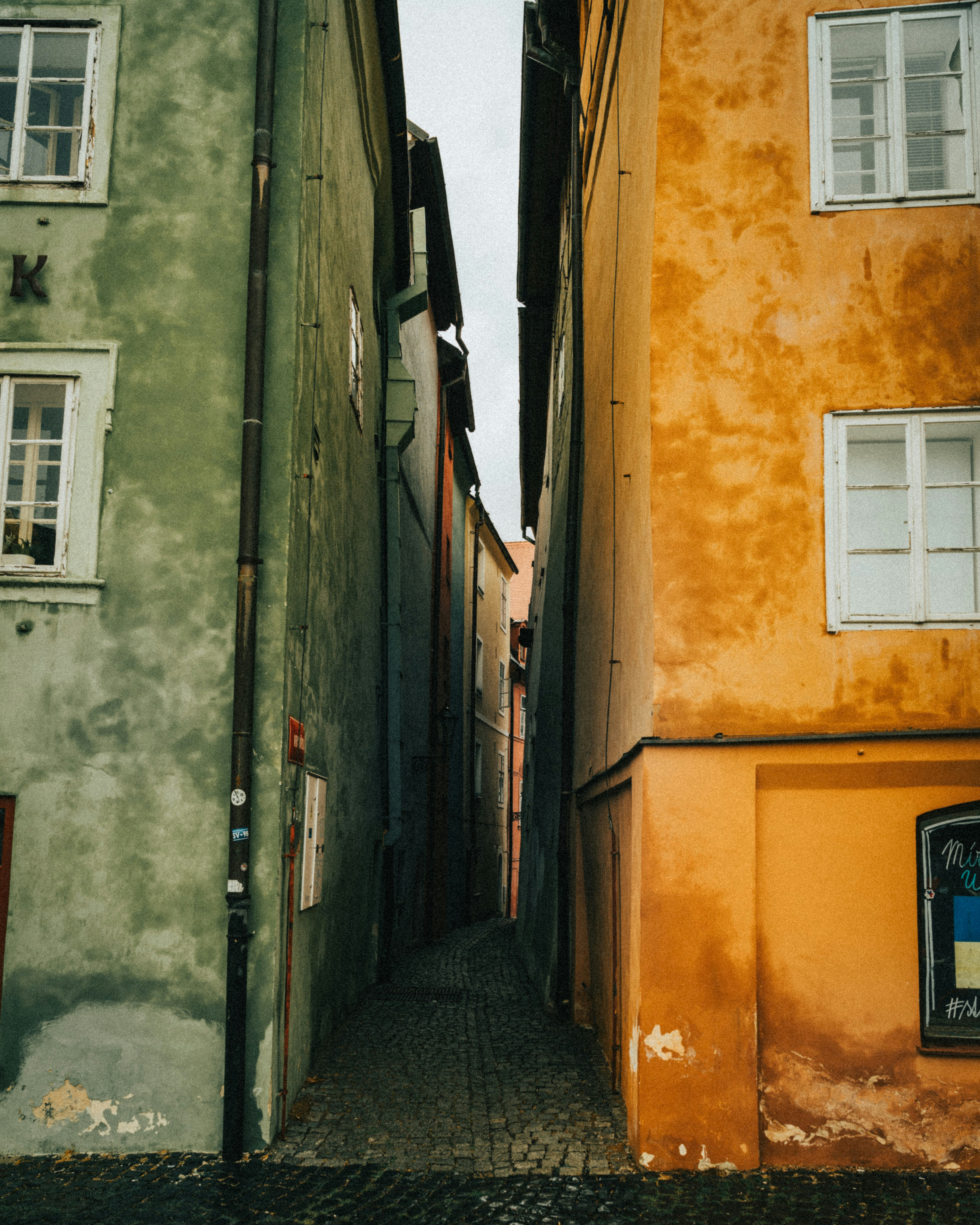 A narrow alleyway between two buildings with windows photo – Free Image ...