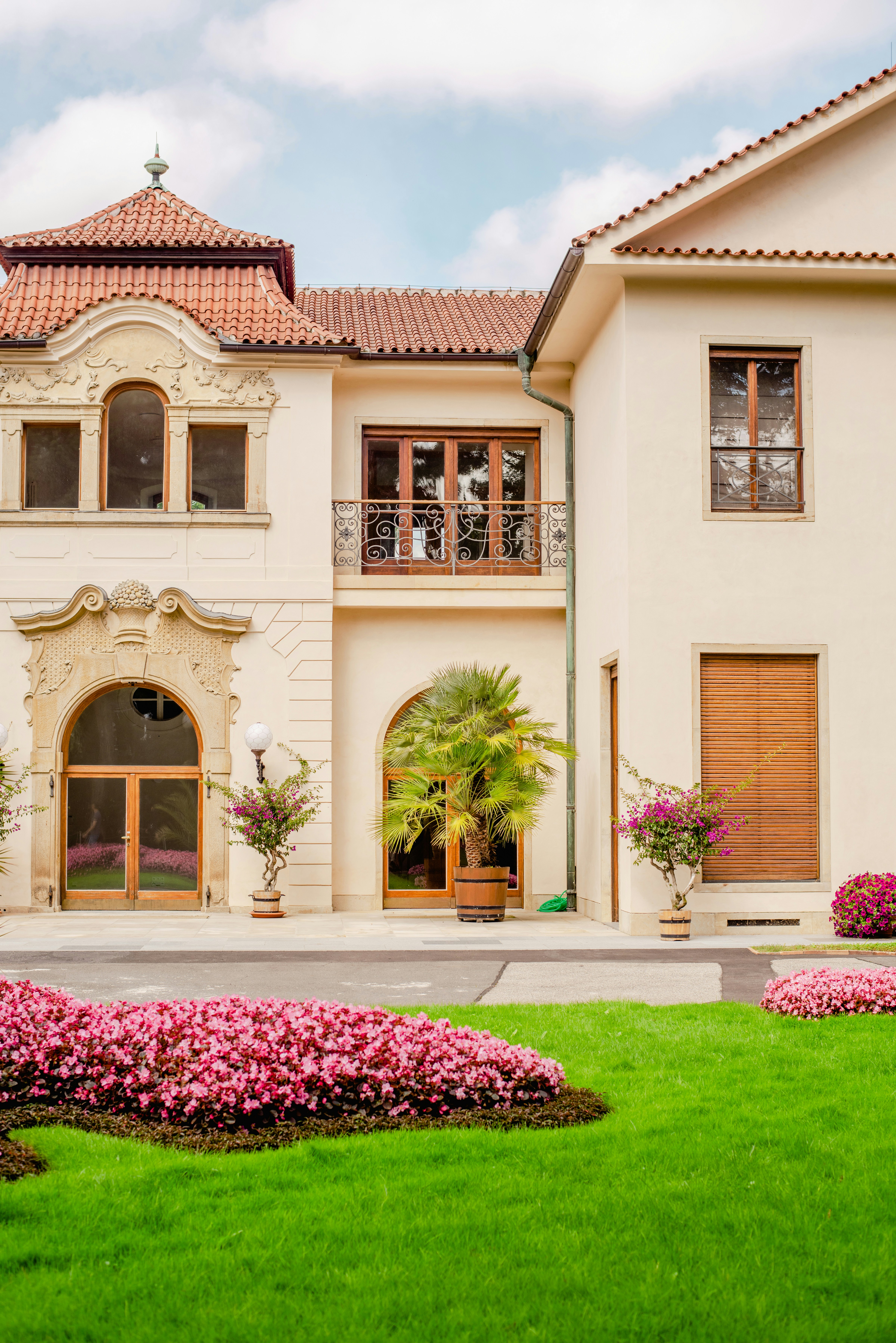 A large white house with pink flowers in front of it photo – Free ...