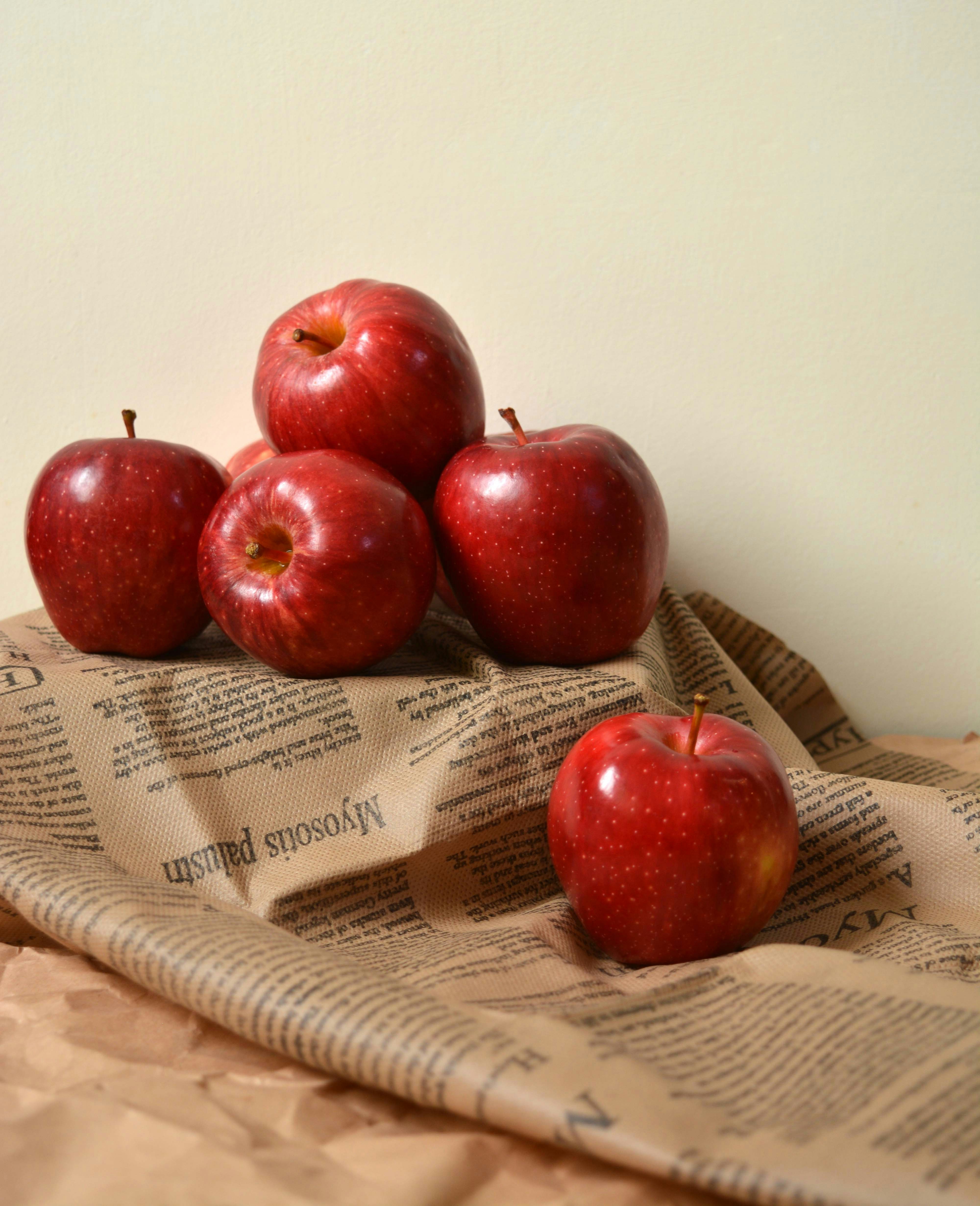 A pile of red apples sitting on top of a newspaper photo – Free Apple ...