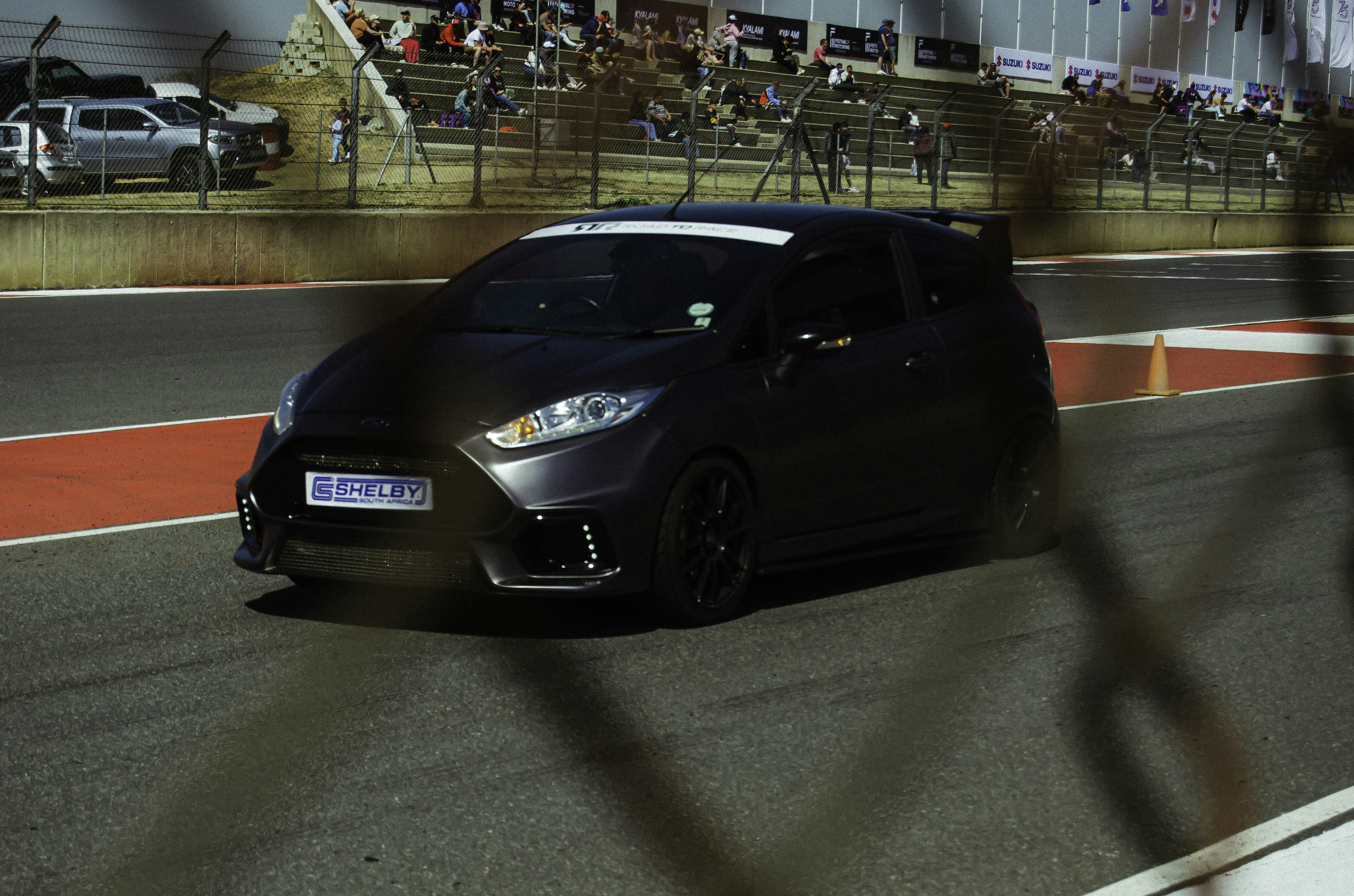 A black car driving down a race track photo – Free Cnr r55 & Image on ...