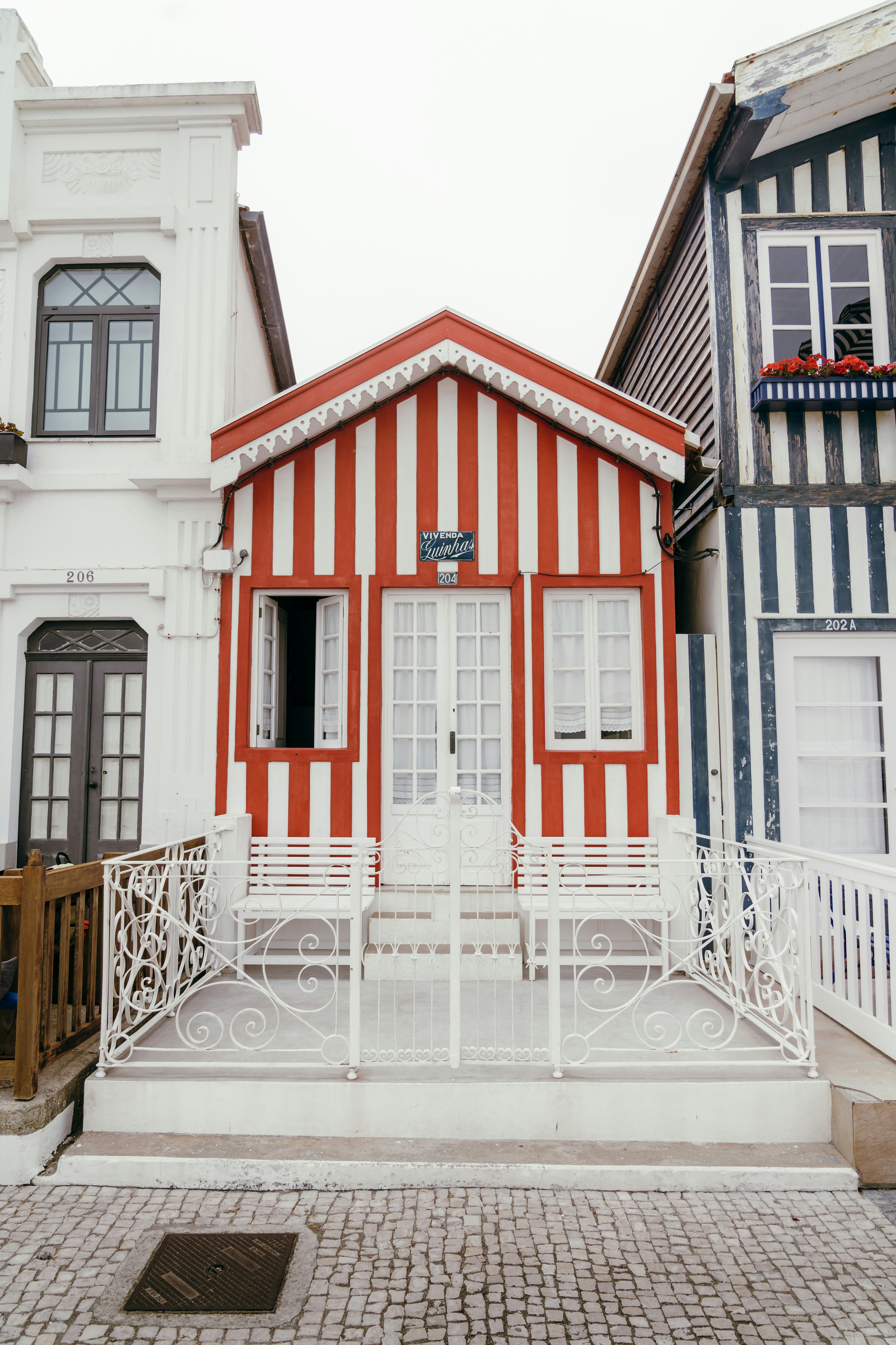 A red and white striped house with a white fence photo – Free House ...