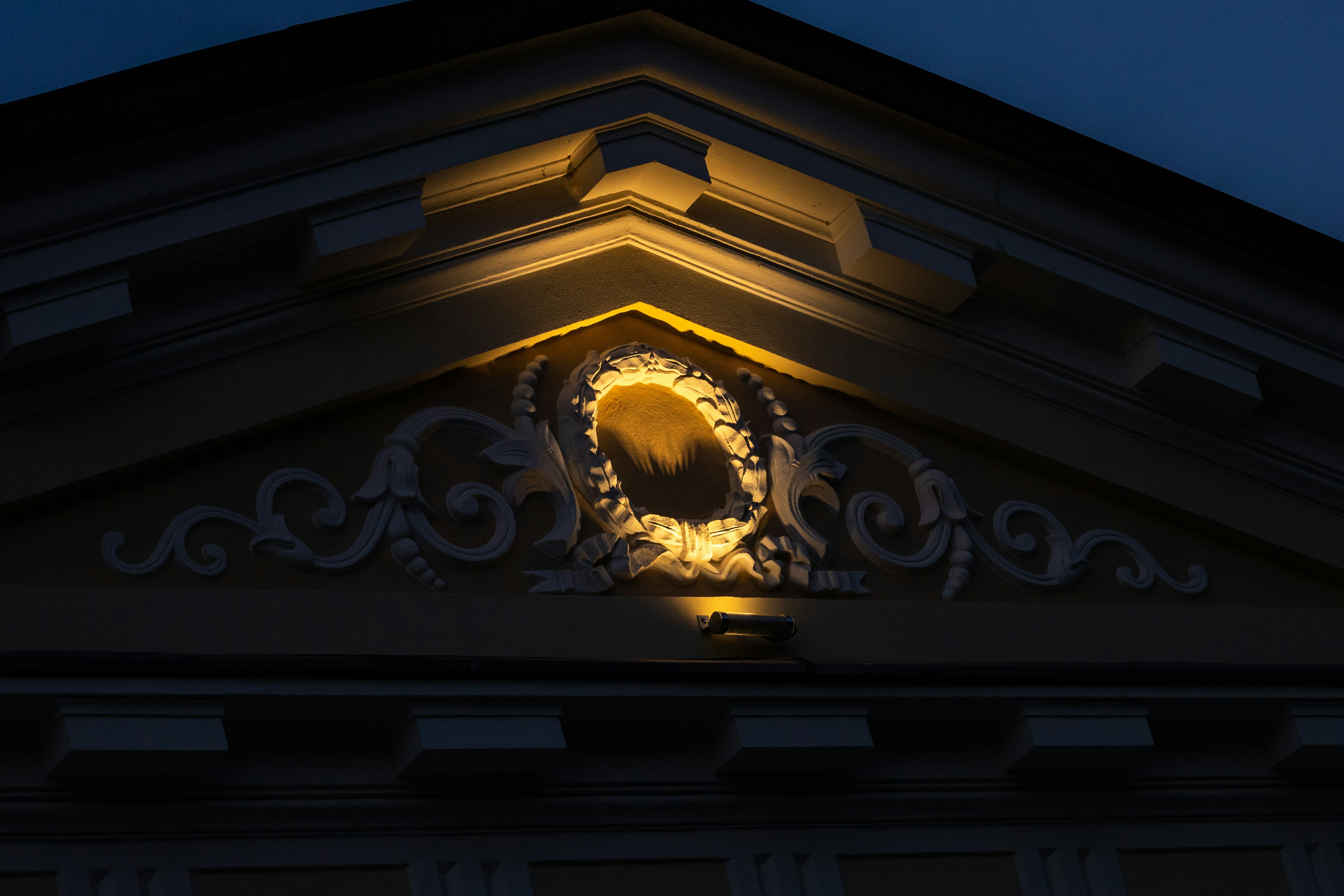 Warm Halo on a Baroque Pediment: Night Highlight of an Ornate Facade