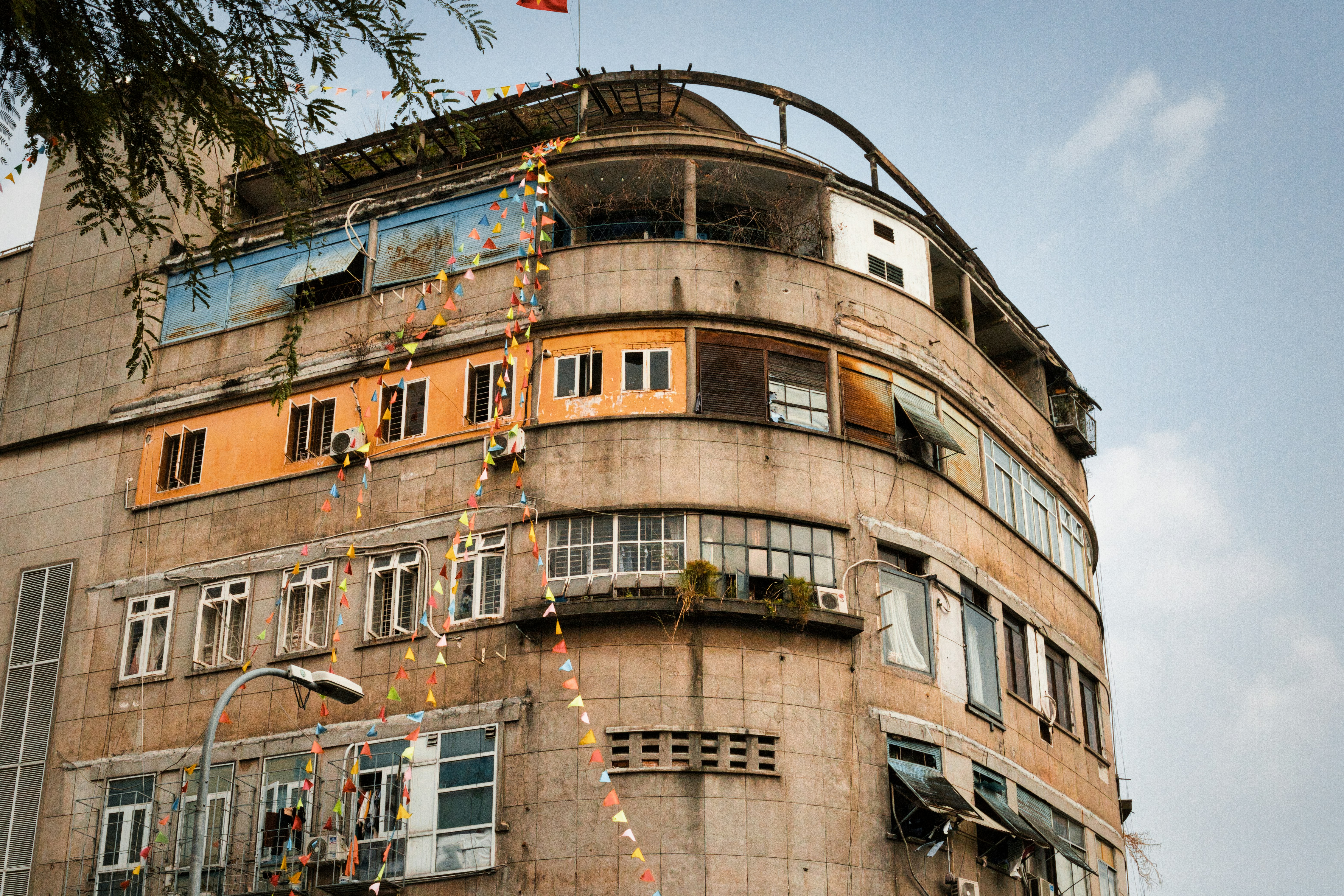Color Flags Draped Across a Weathered Circular Facade