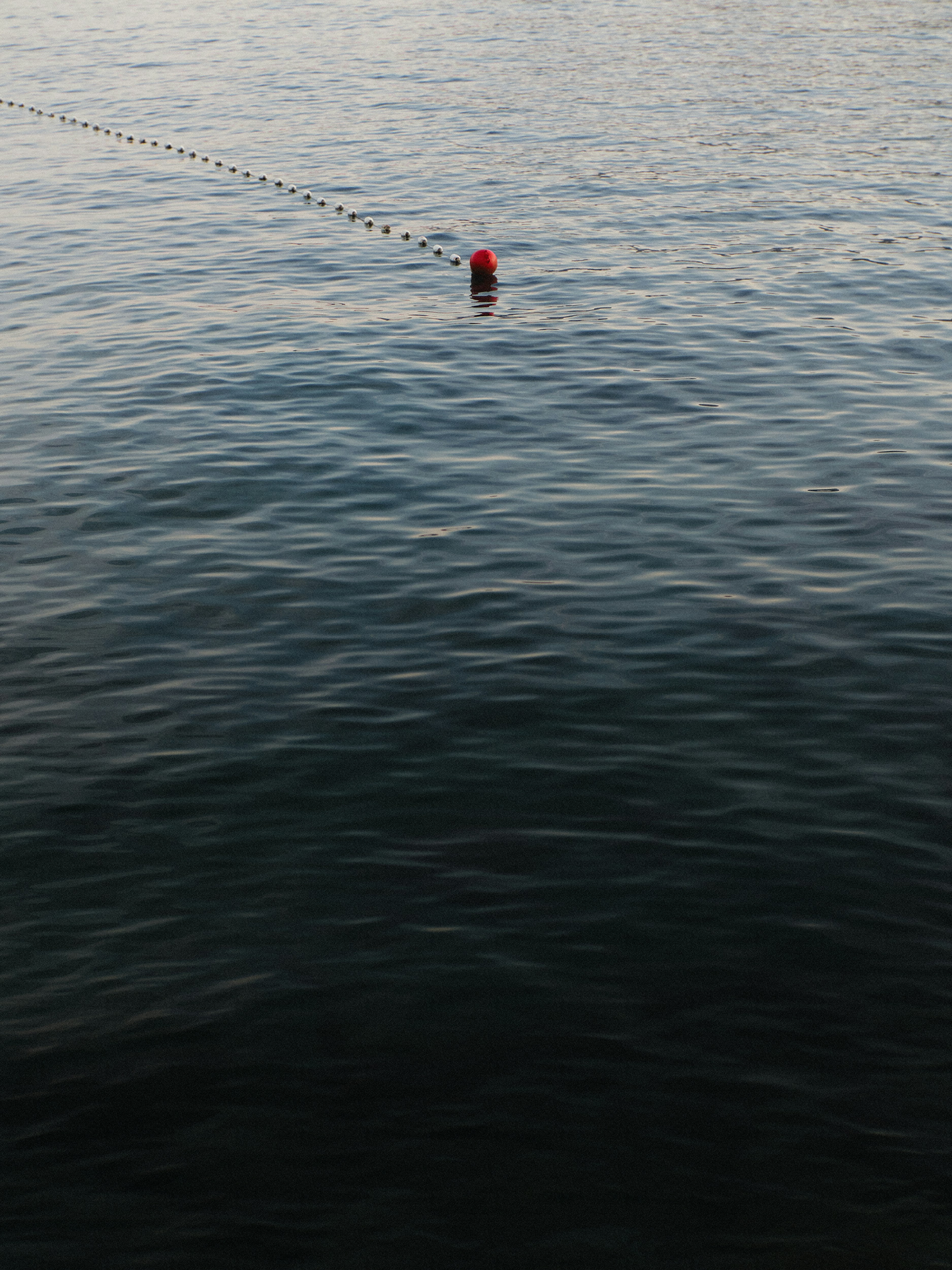 A red buoy floating in the middle of a body of water photo – Free ...