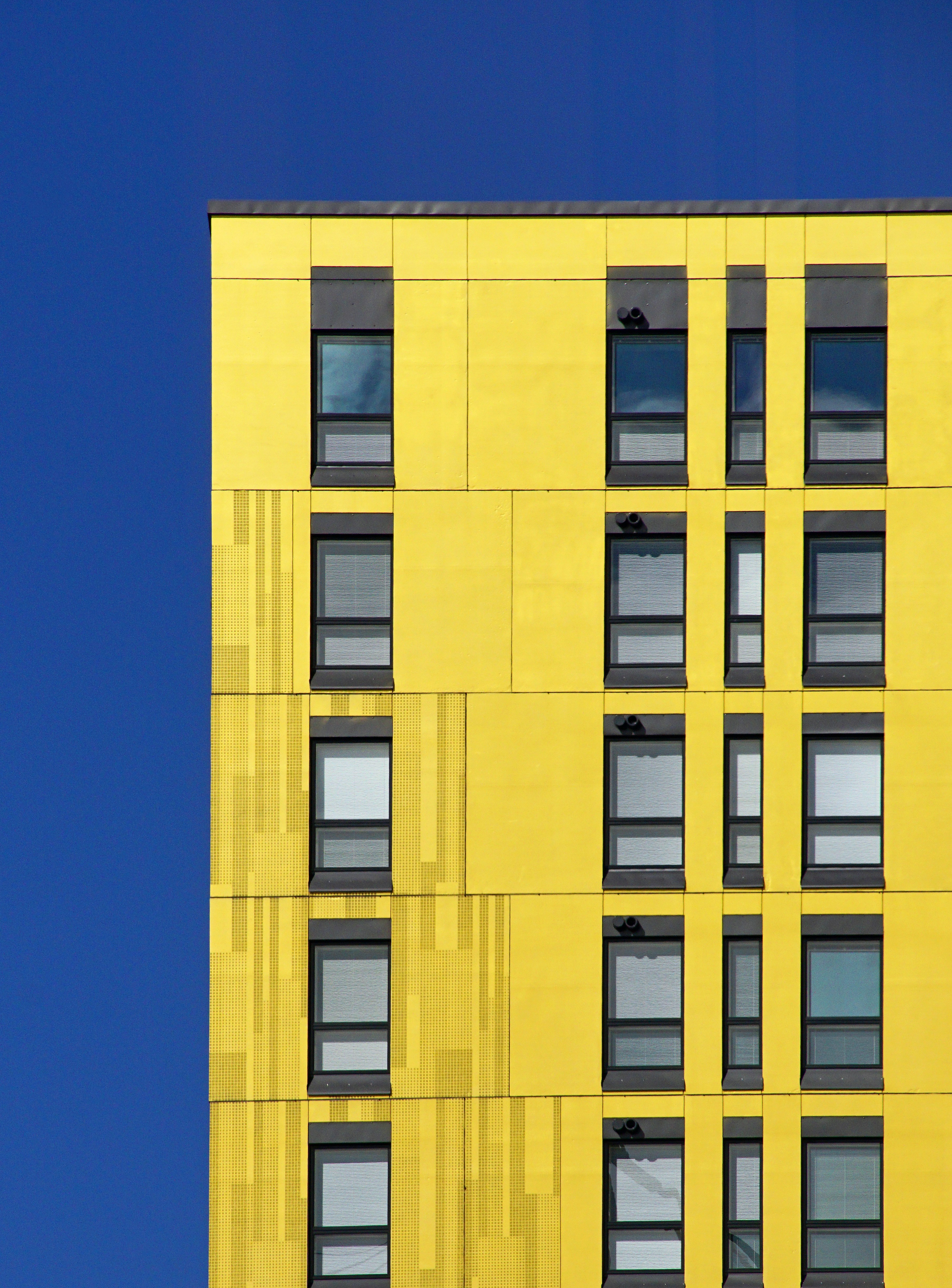 A tall yellow building with lots of windows photo – Free Architecture ...