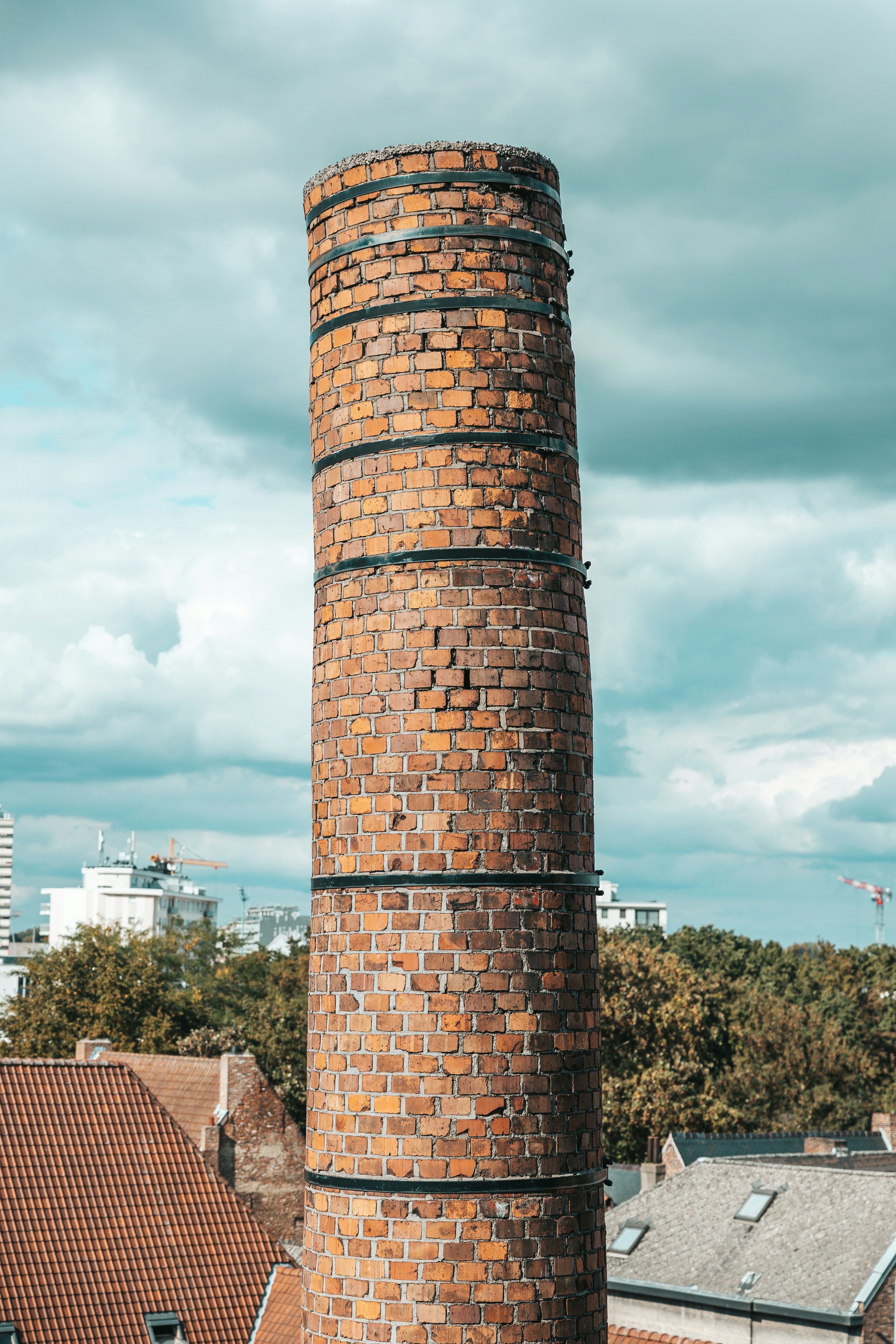 Brick Chimney Rising Above the Urban Roofline