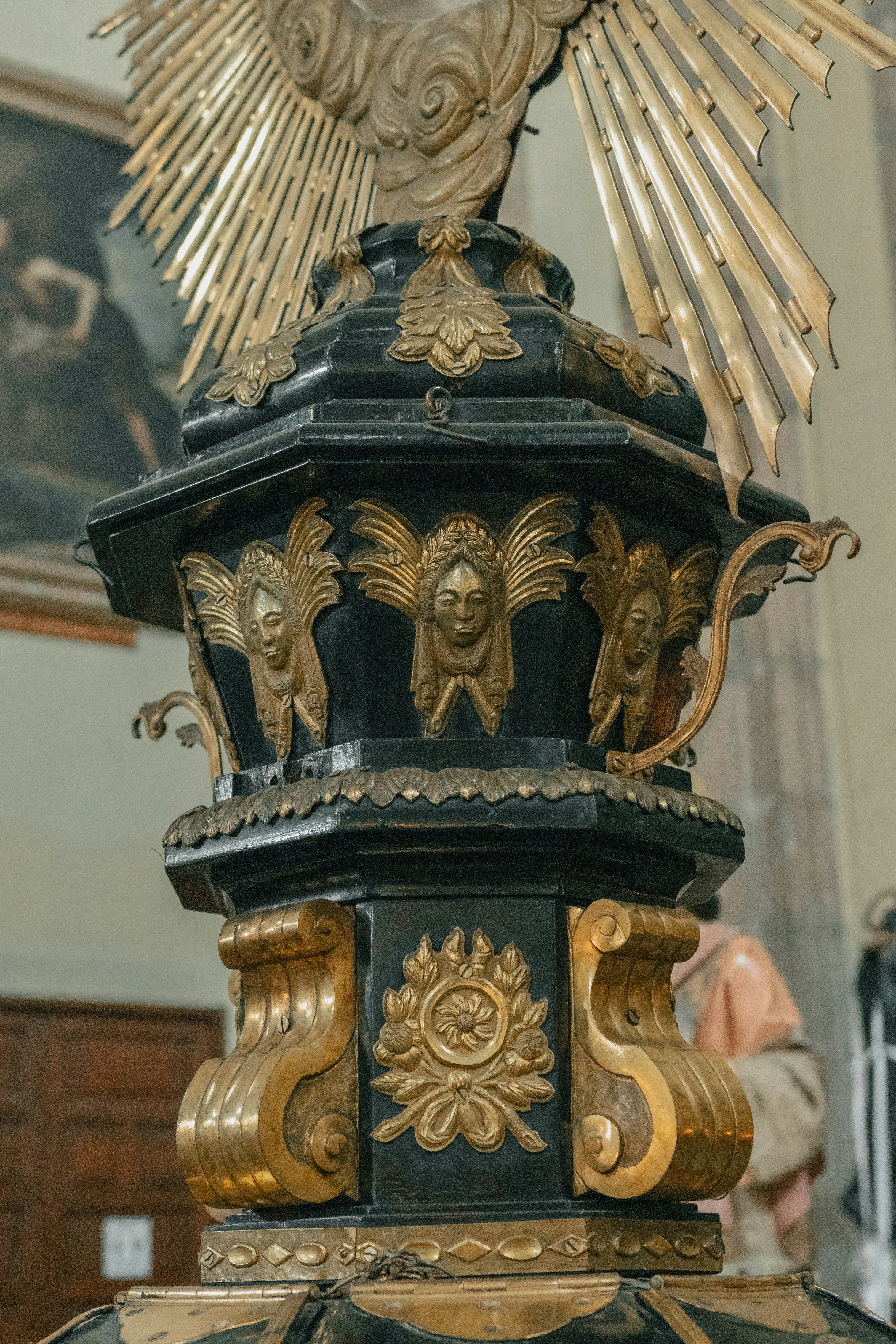 Angelic Reliefs Crown a Black-Gold Pedestal in a Historic Interior