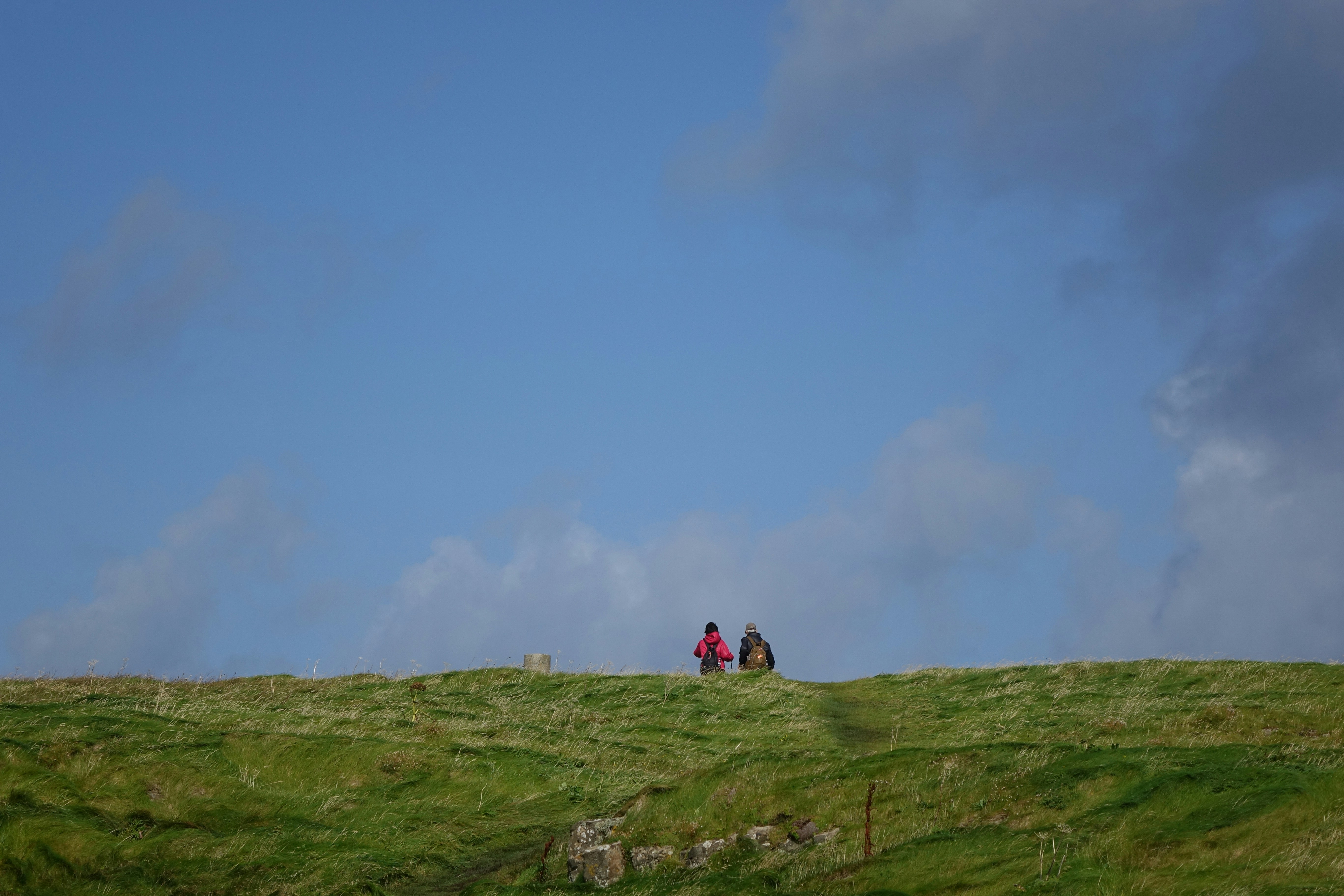 A couple of people that are standing on a hill photo – Free Isle of ...