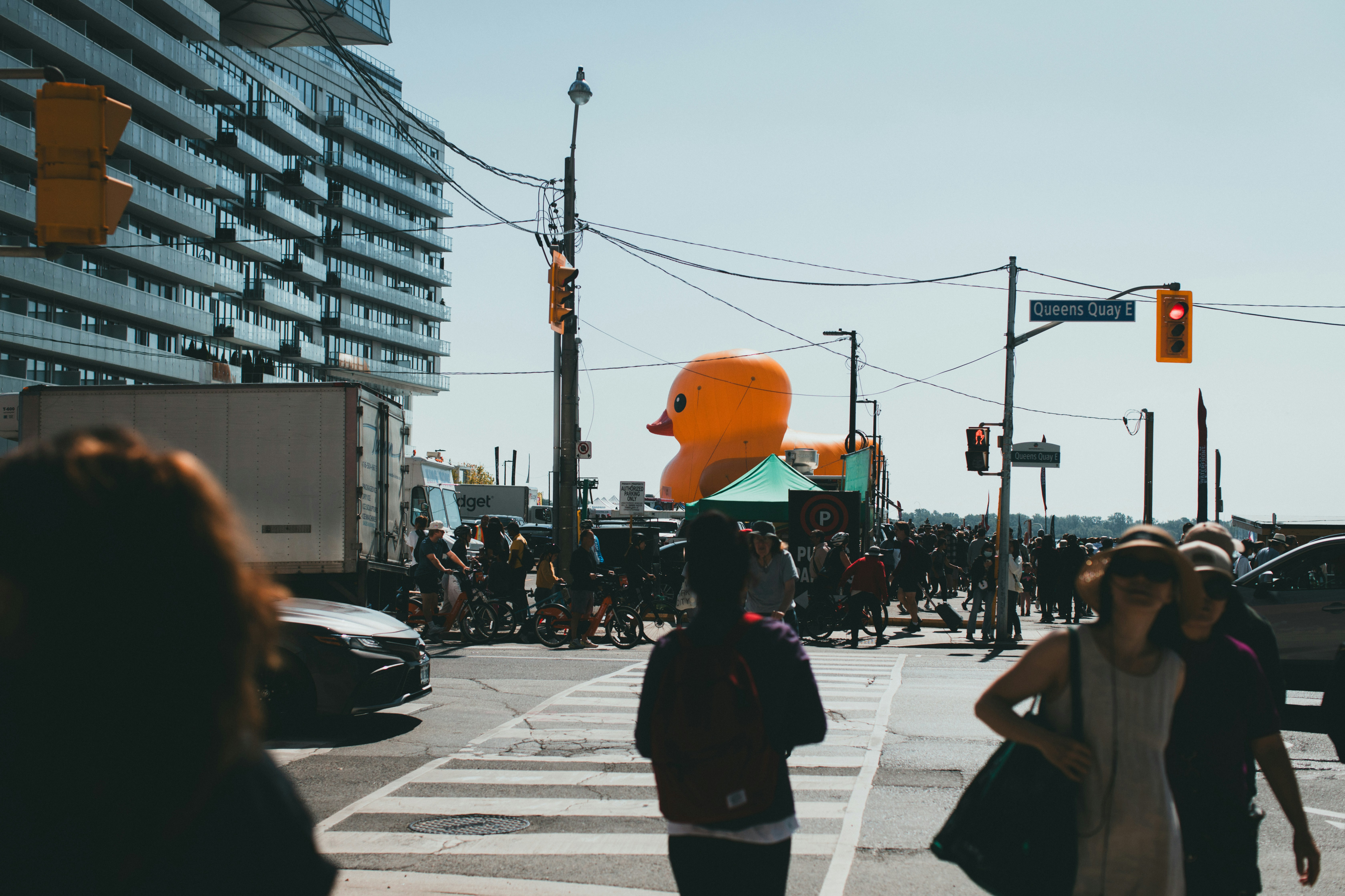Giant Yellow Rubber Duck Looms Over a Crowded City Crosswalk