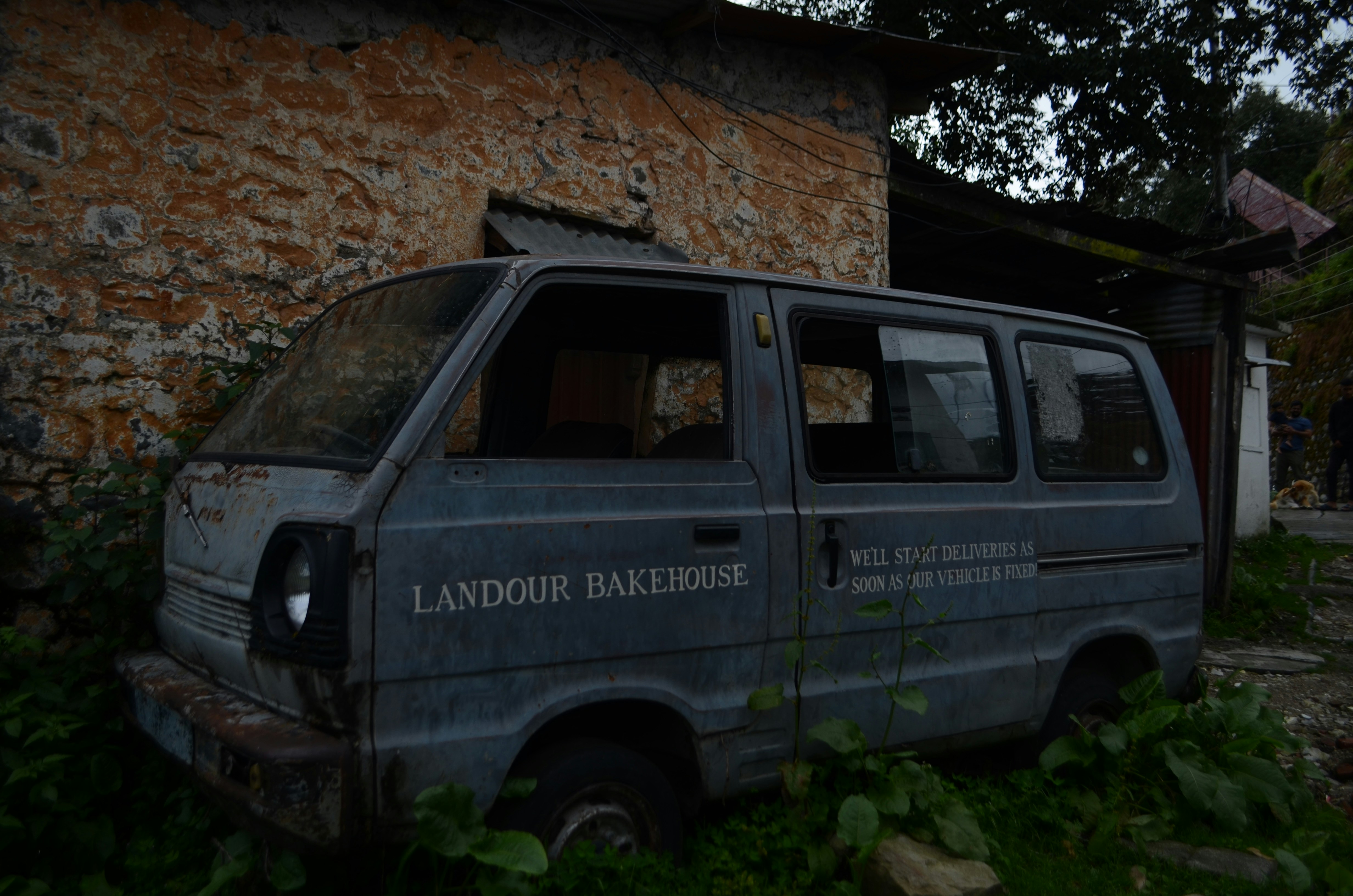 Relic on Wheels: a weathered blue van resting beside an ivy-clad ruin
