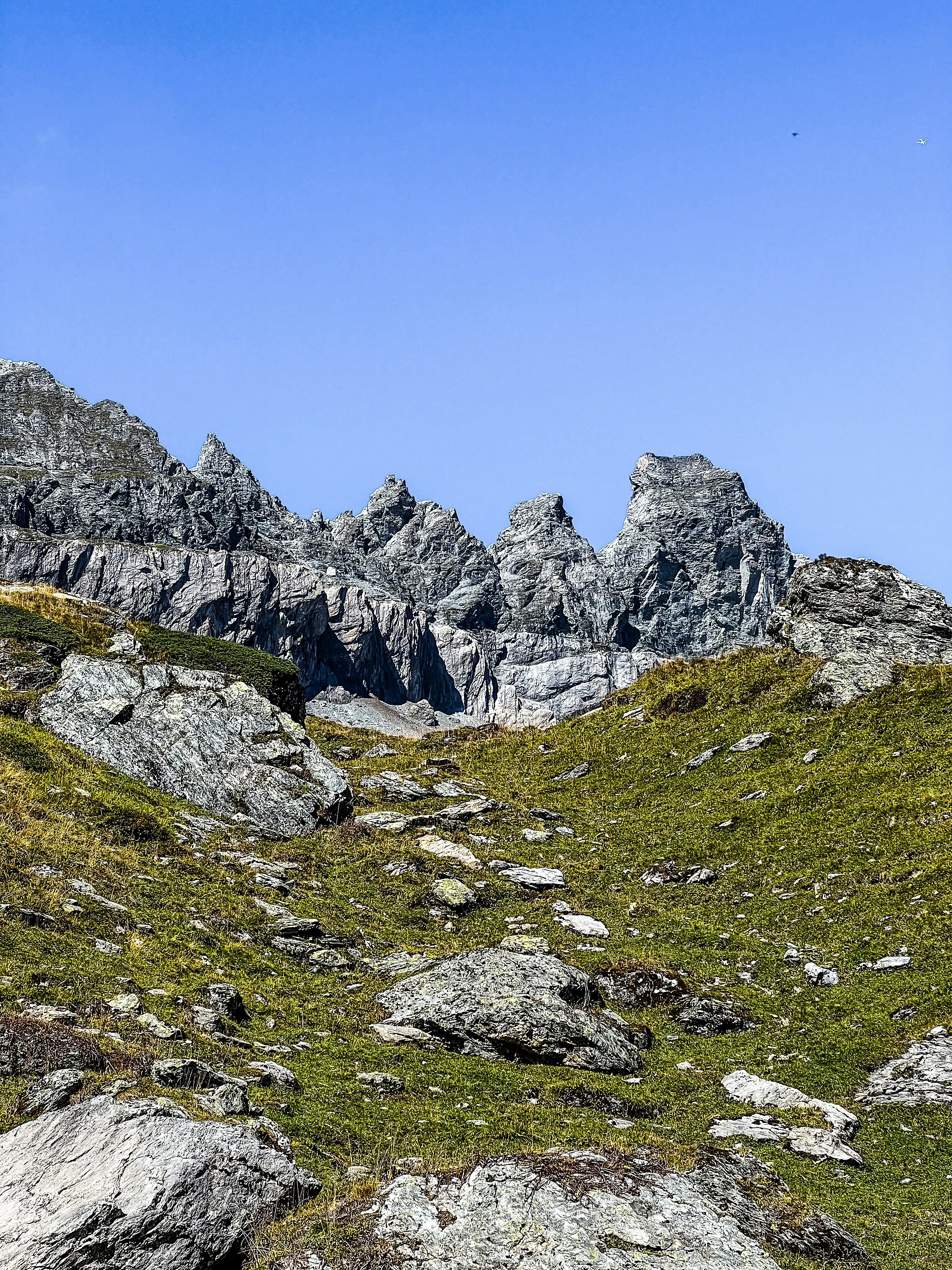 A grassy hill with rocks and grass in the foreground photo – Free ...