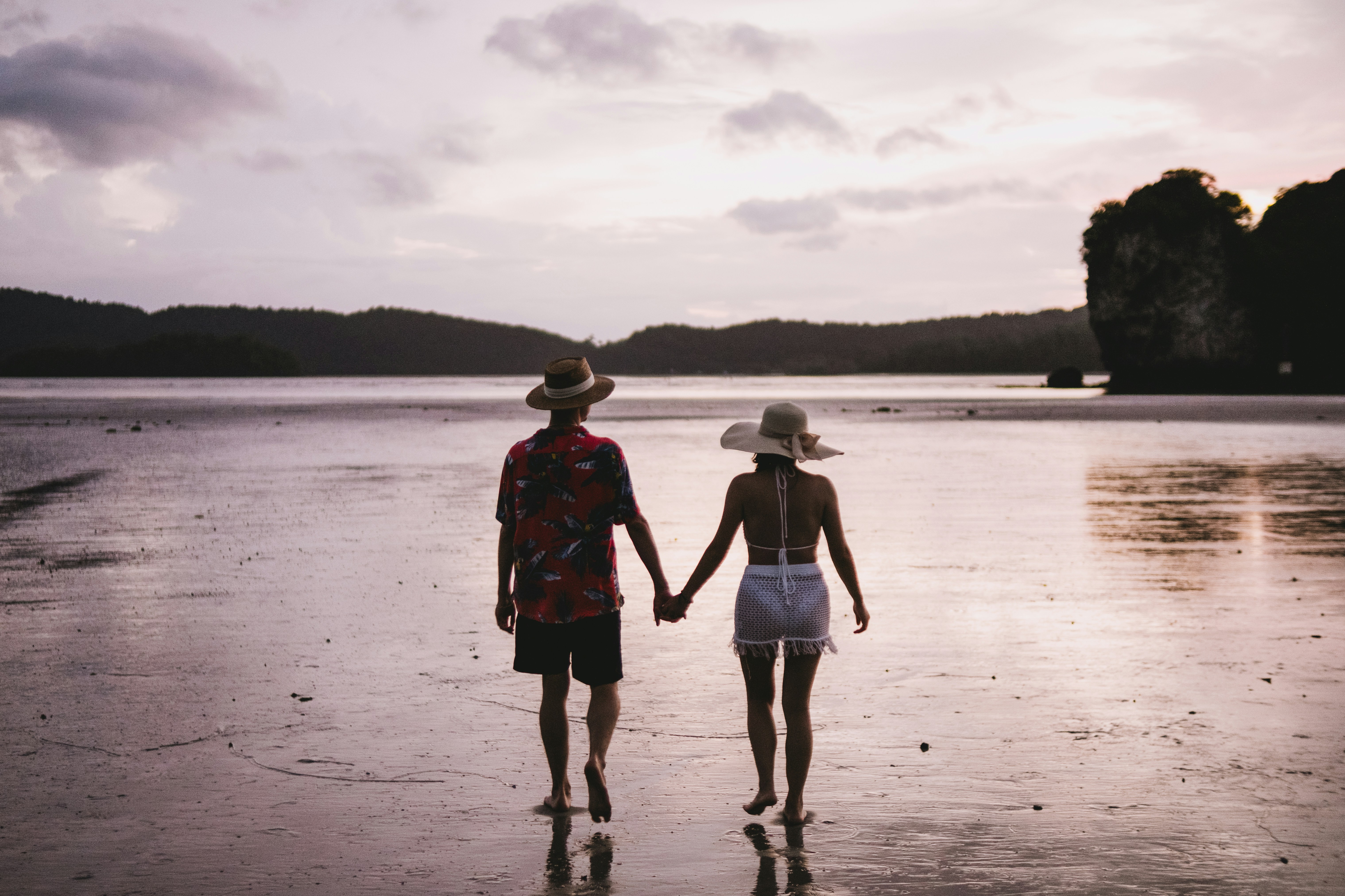 Two people walking on a beach holding hands photo – Free Sunset Image ...