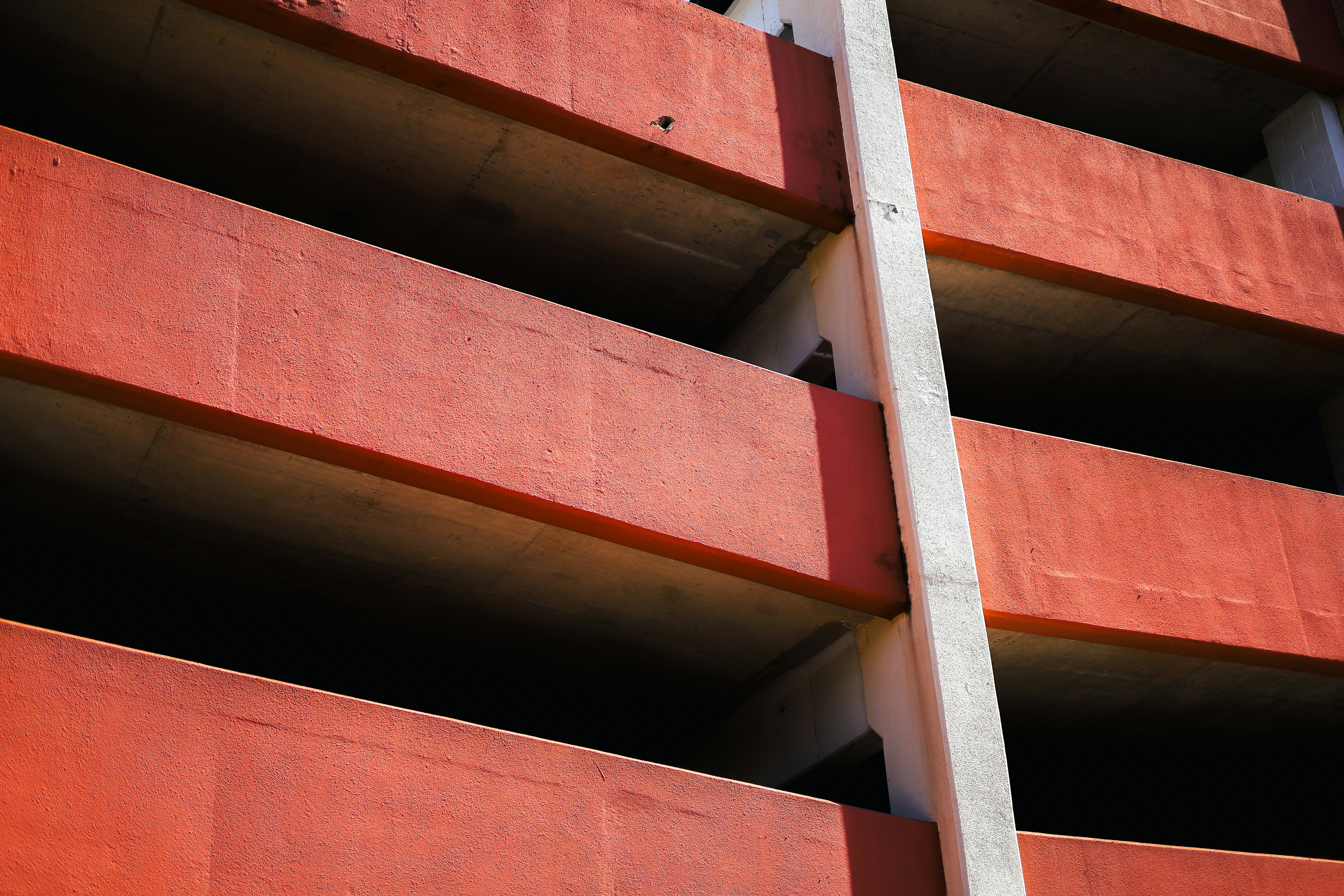a tall red building with balconies next to it