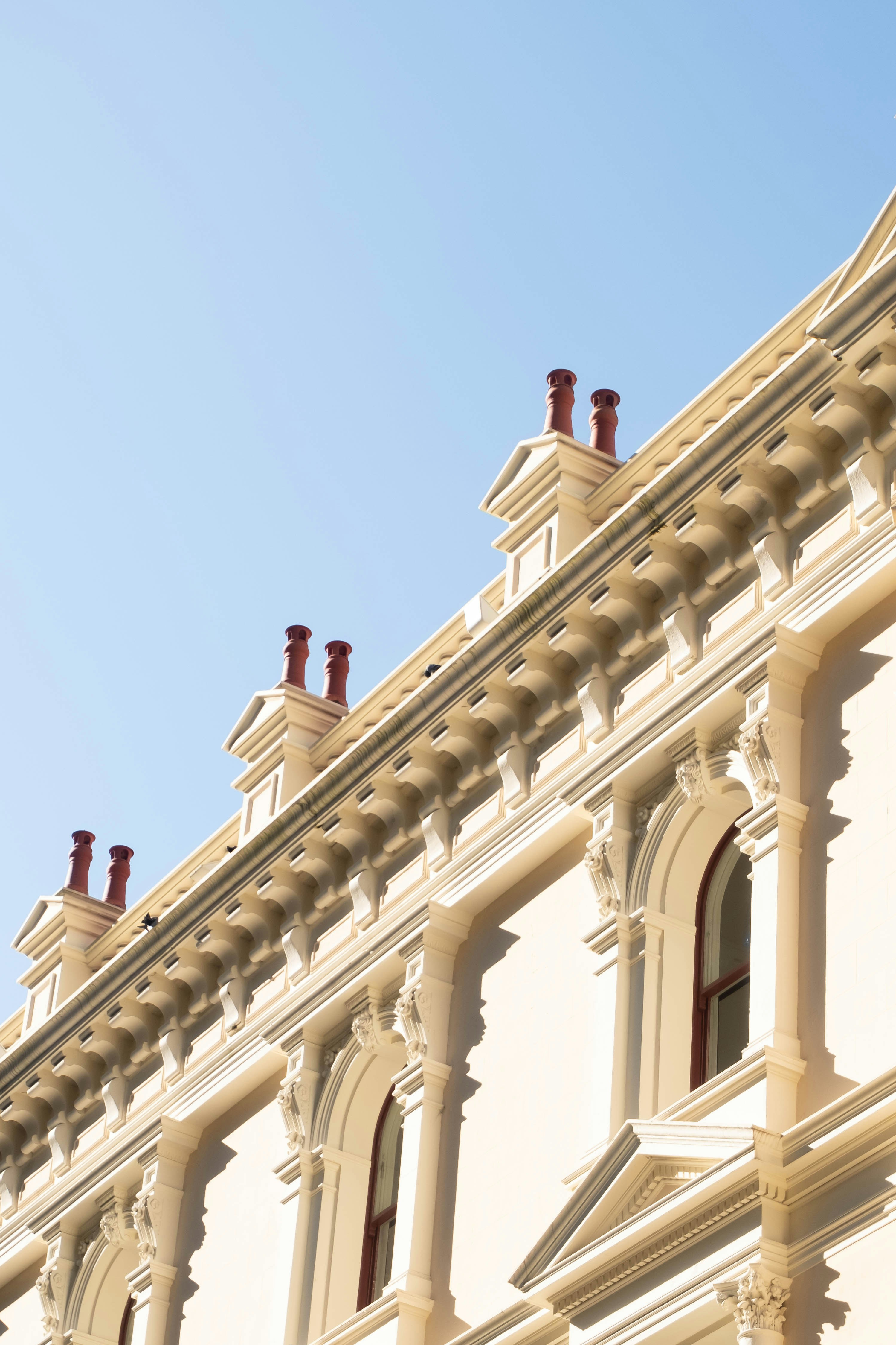 Ornate building facade showcasing intricate architectural details against a bright blue sky.