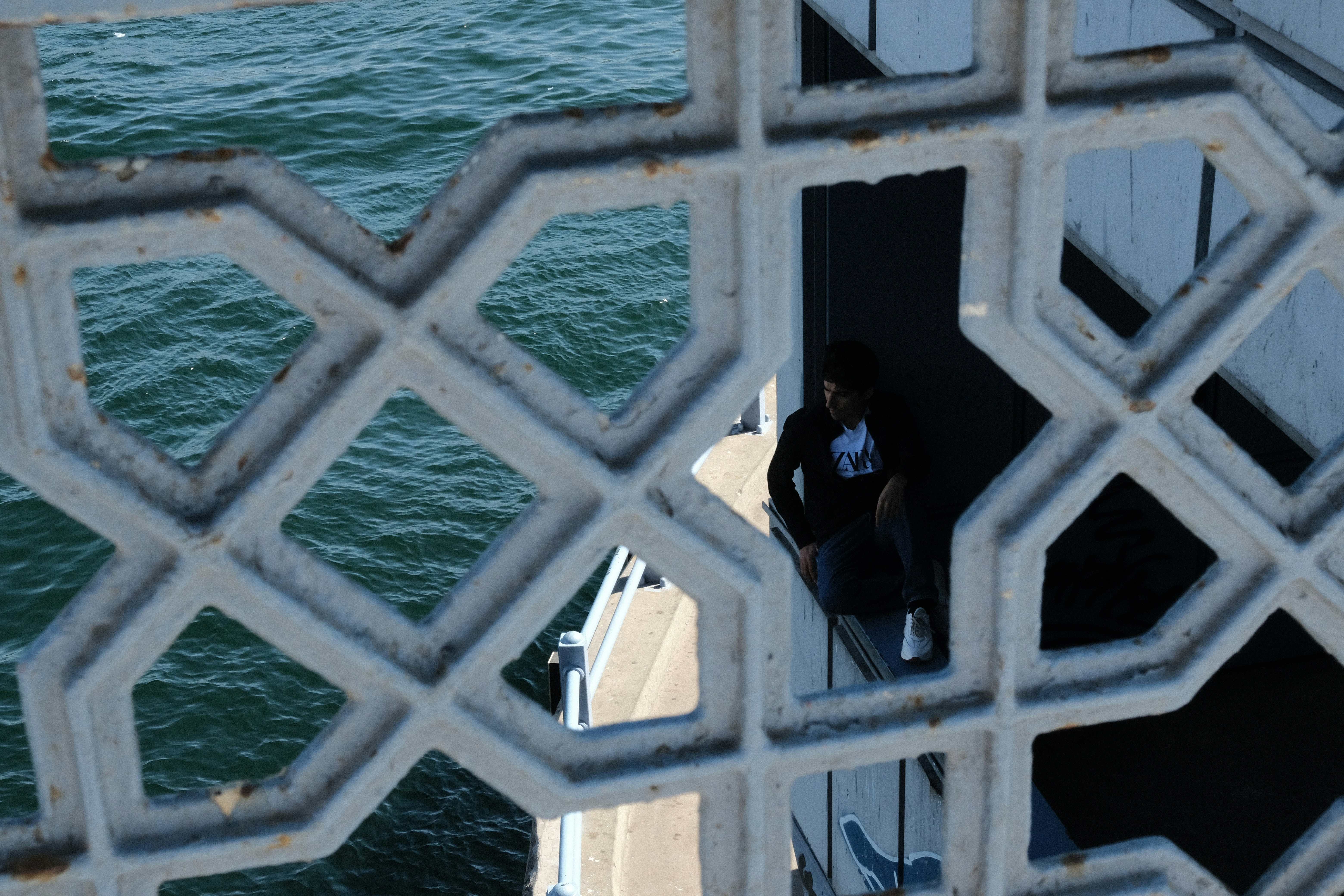 Harbor Lattice Portrait: A Lone Figure Framed by Geometric Grids