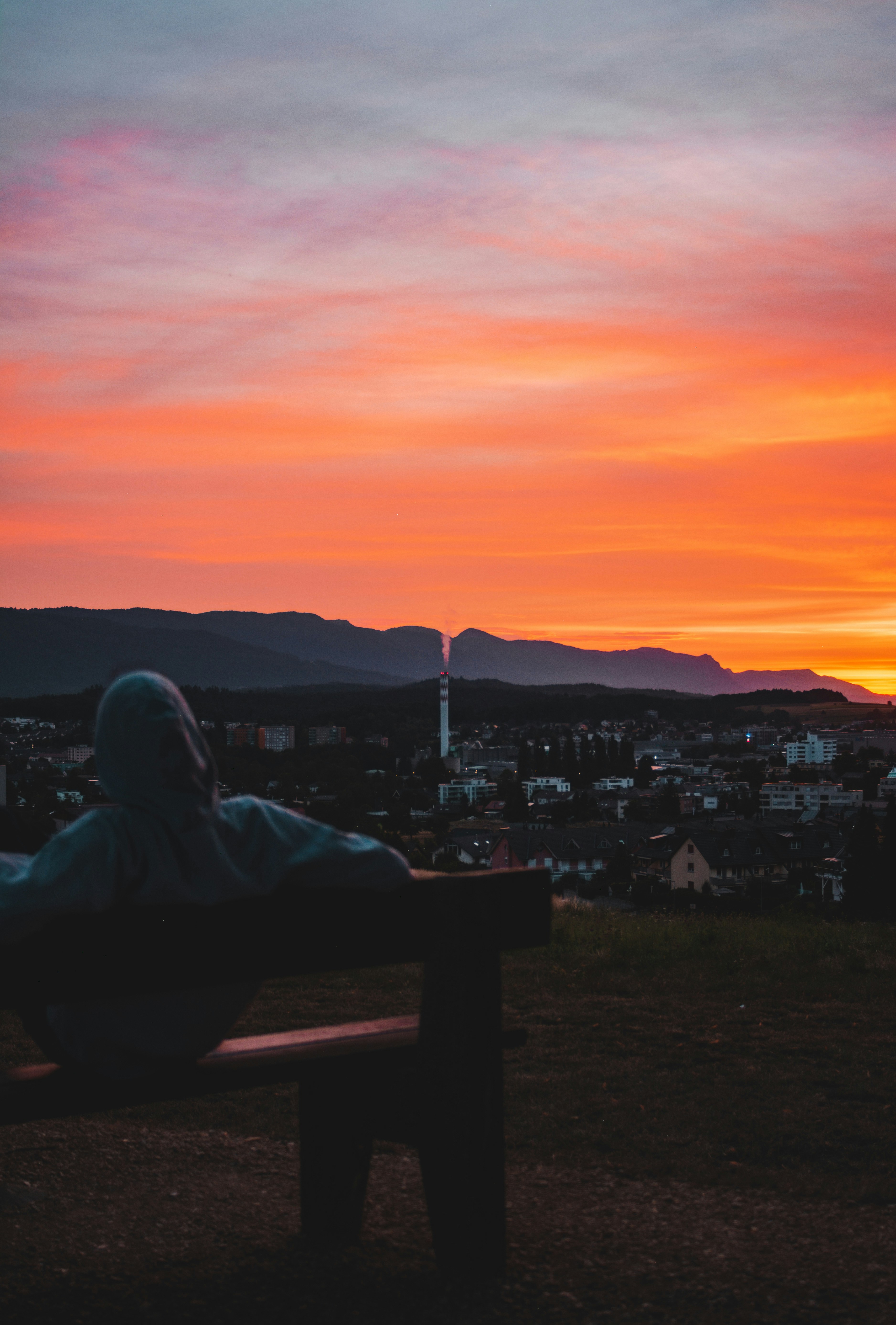 Dusk Silhouette on a Hilltop Bench Over the Sleeping City