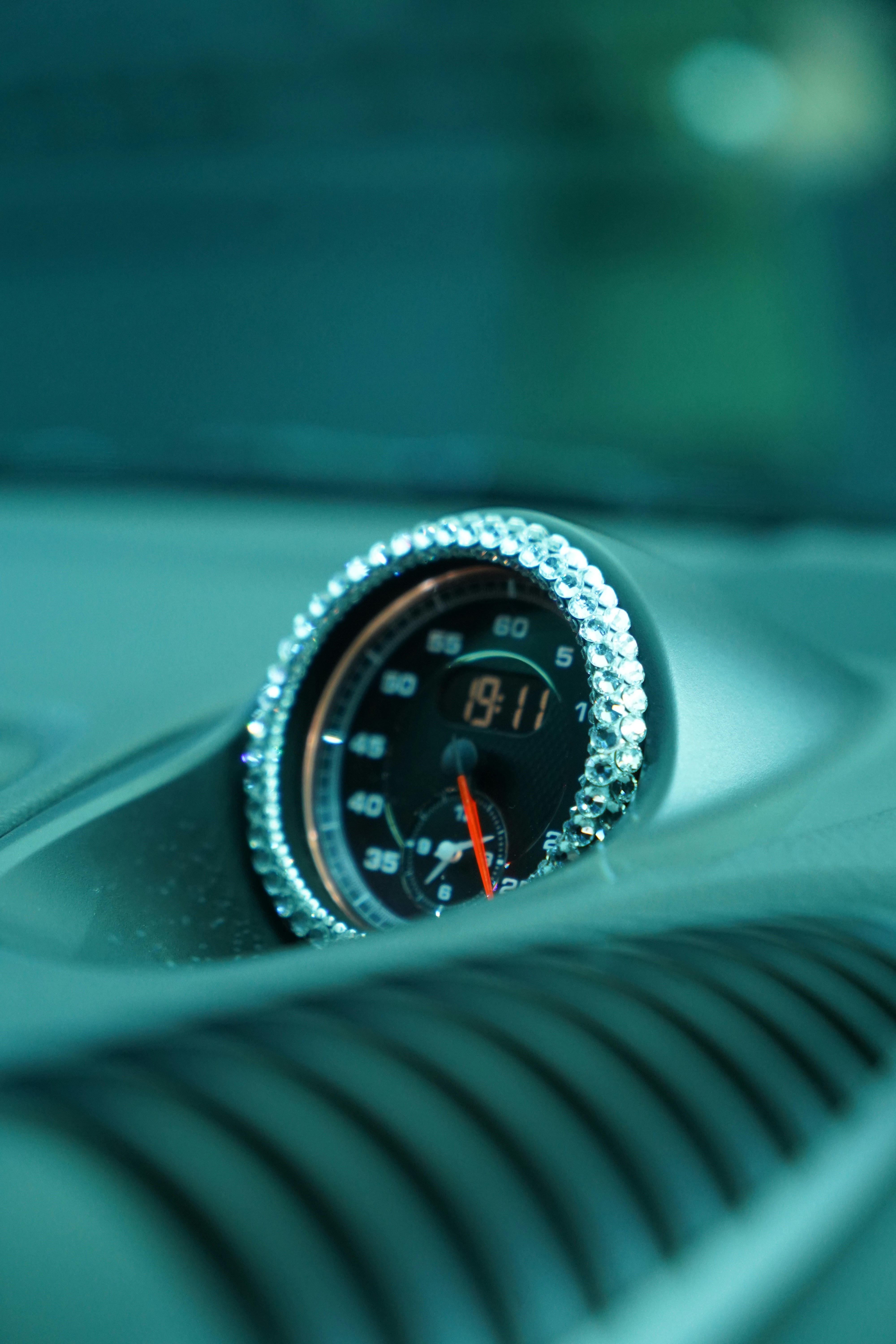 Teal-lit Diamond-Bezel Dashboard Clock in a Luxury Car Cockpit
