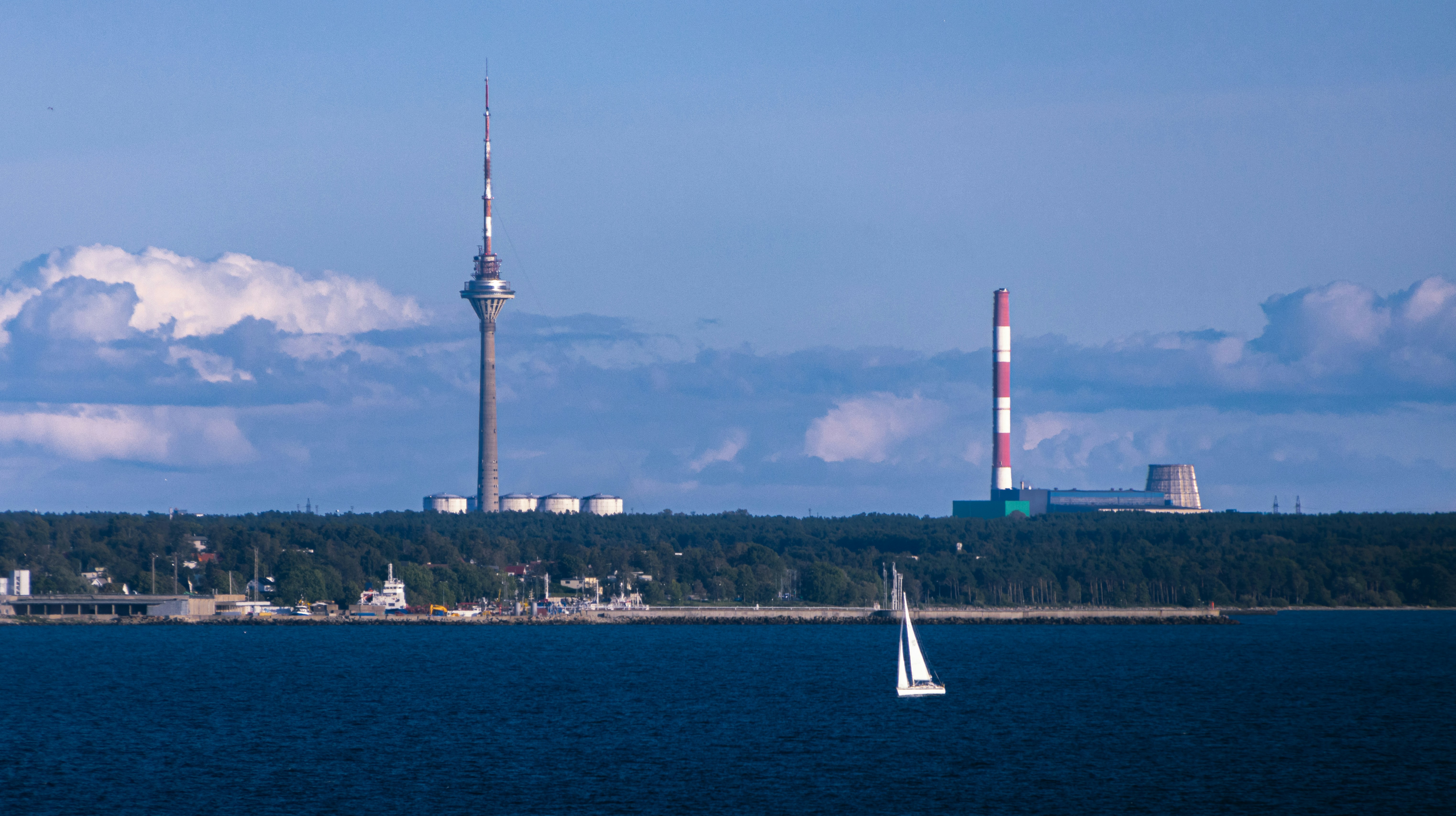 White Sail Beneath an Industrial Skyline