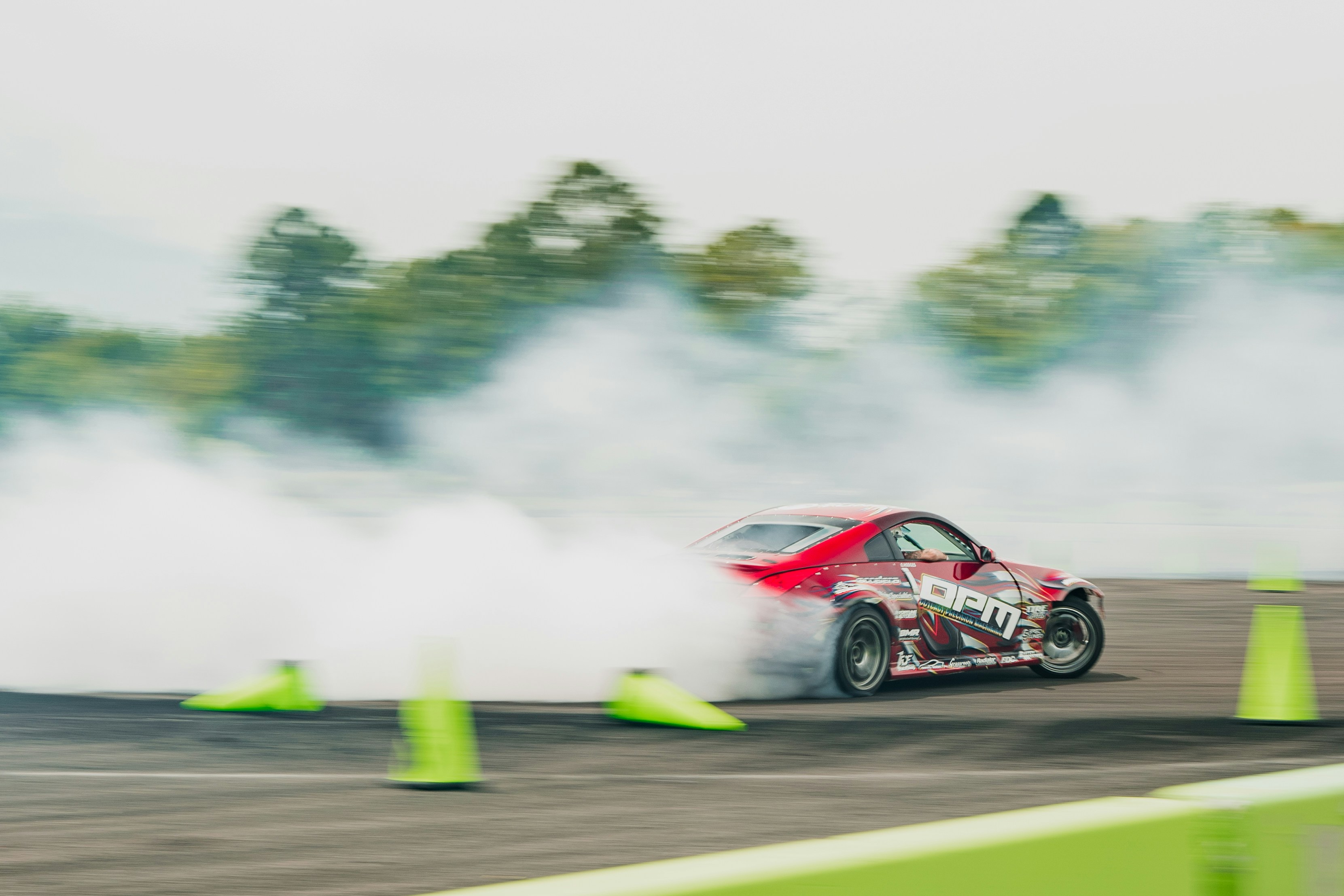 A car driving around a track with a lot of smoke coming out of it photo ...