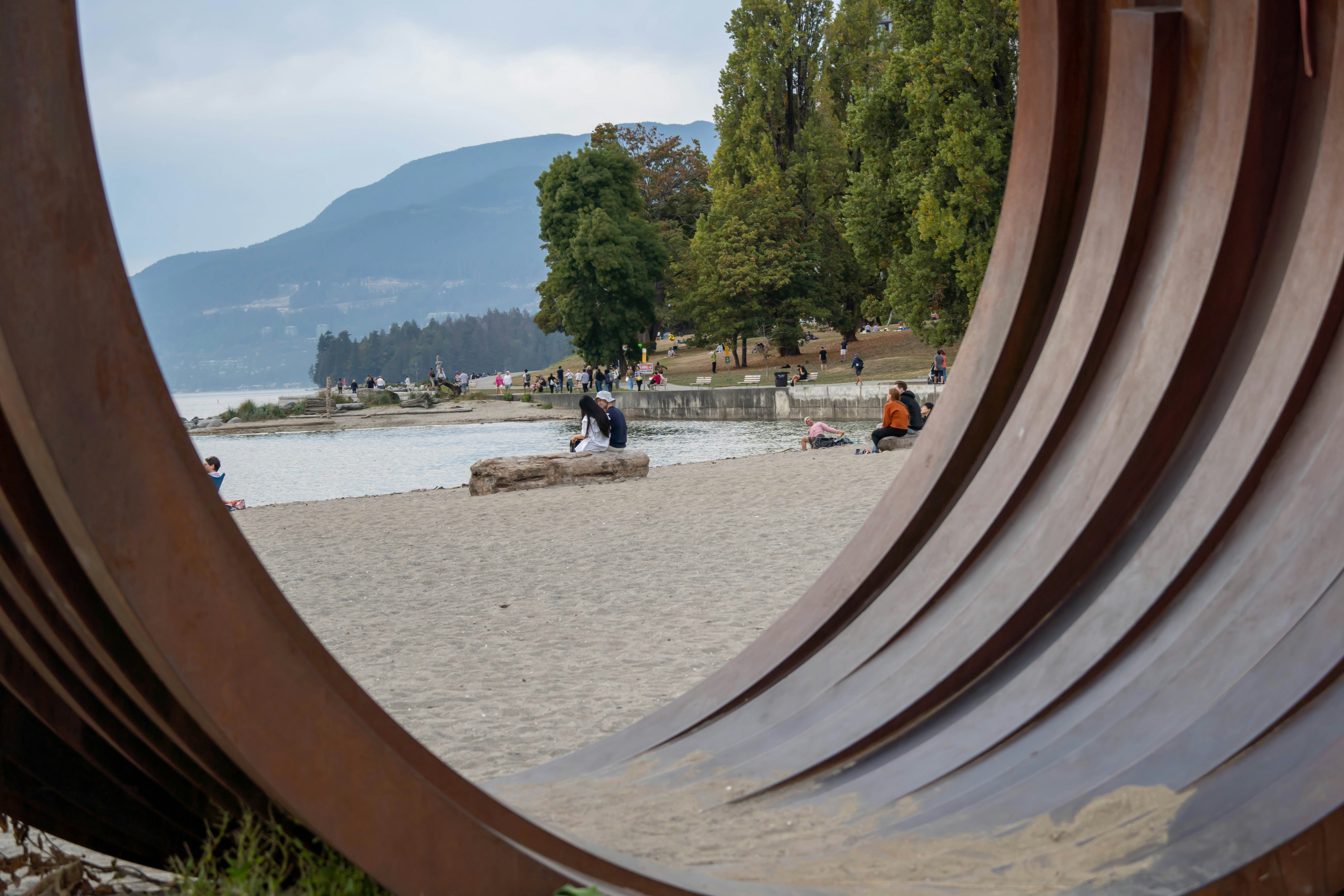 A view of a beach through a circular window photo – Free Beach Image on ...