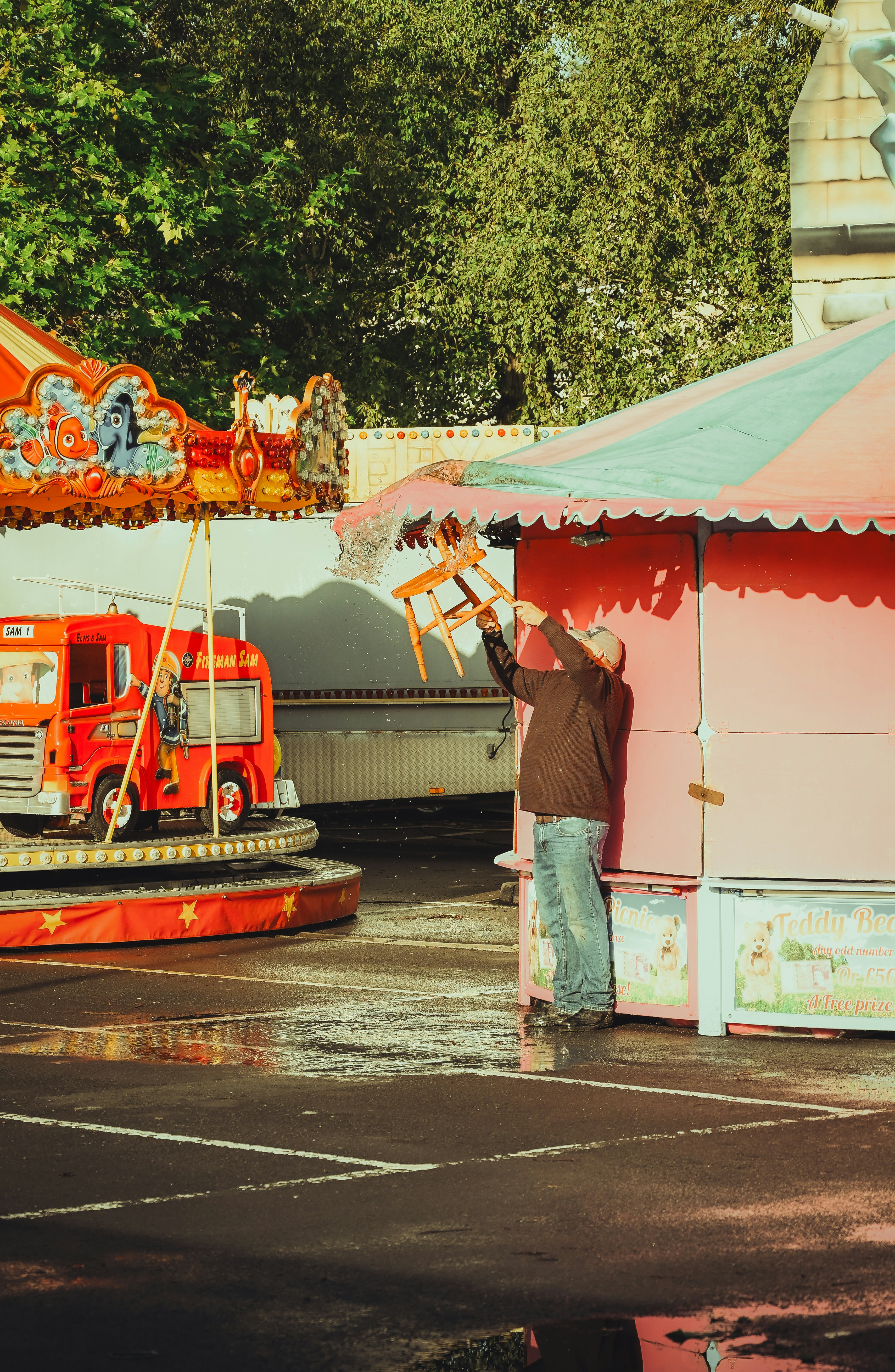 The fair's in town. I love the emptiness of a closed fair in the day, no lights, no people, no noise. Eerie. This guy was clearing the rain from the roof of this stall using a chair.