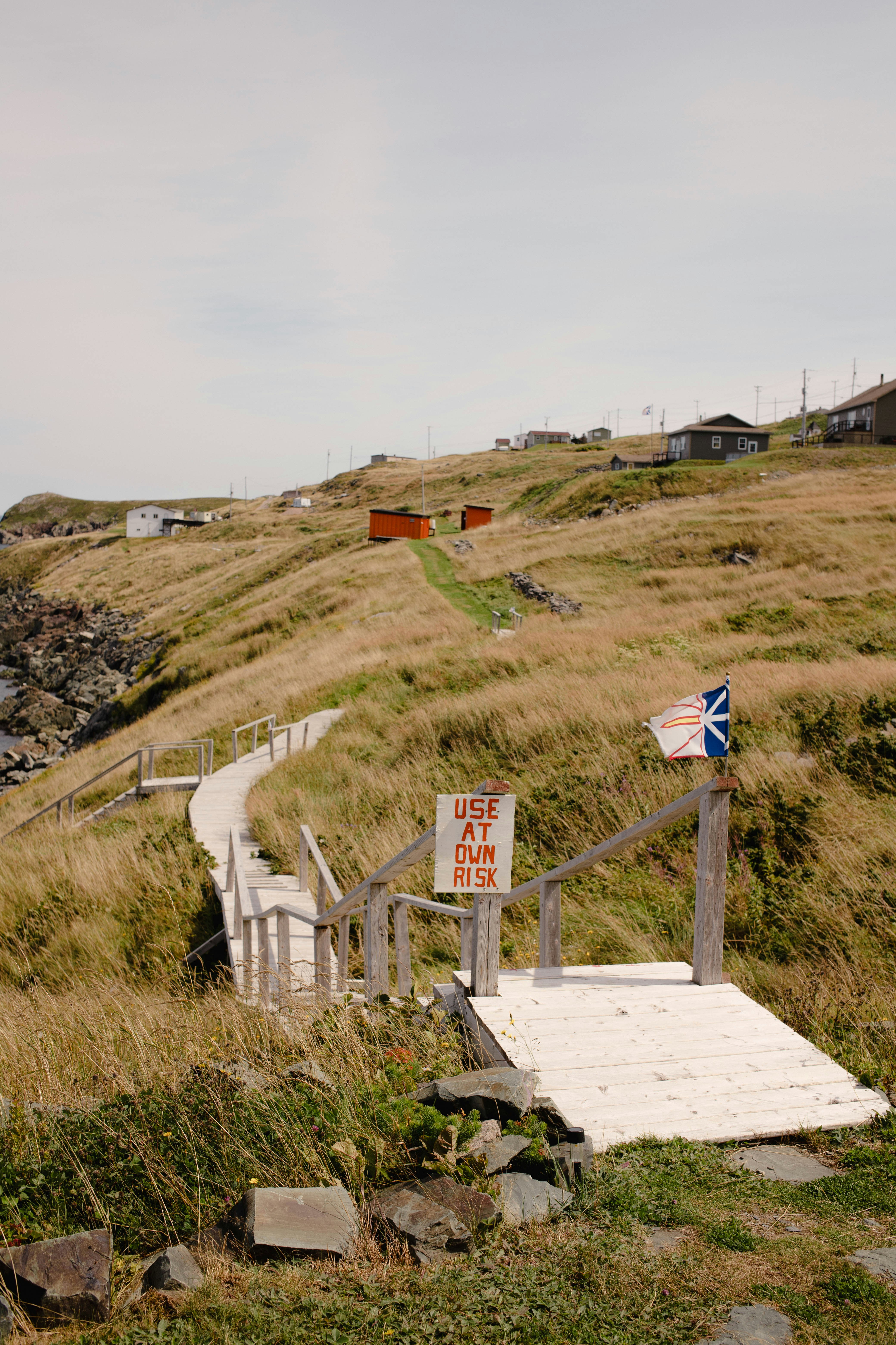 A wooden ramp leading to a sign on a hill photo – Free Mountains Image ...