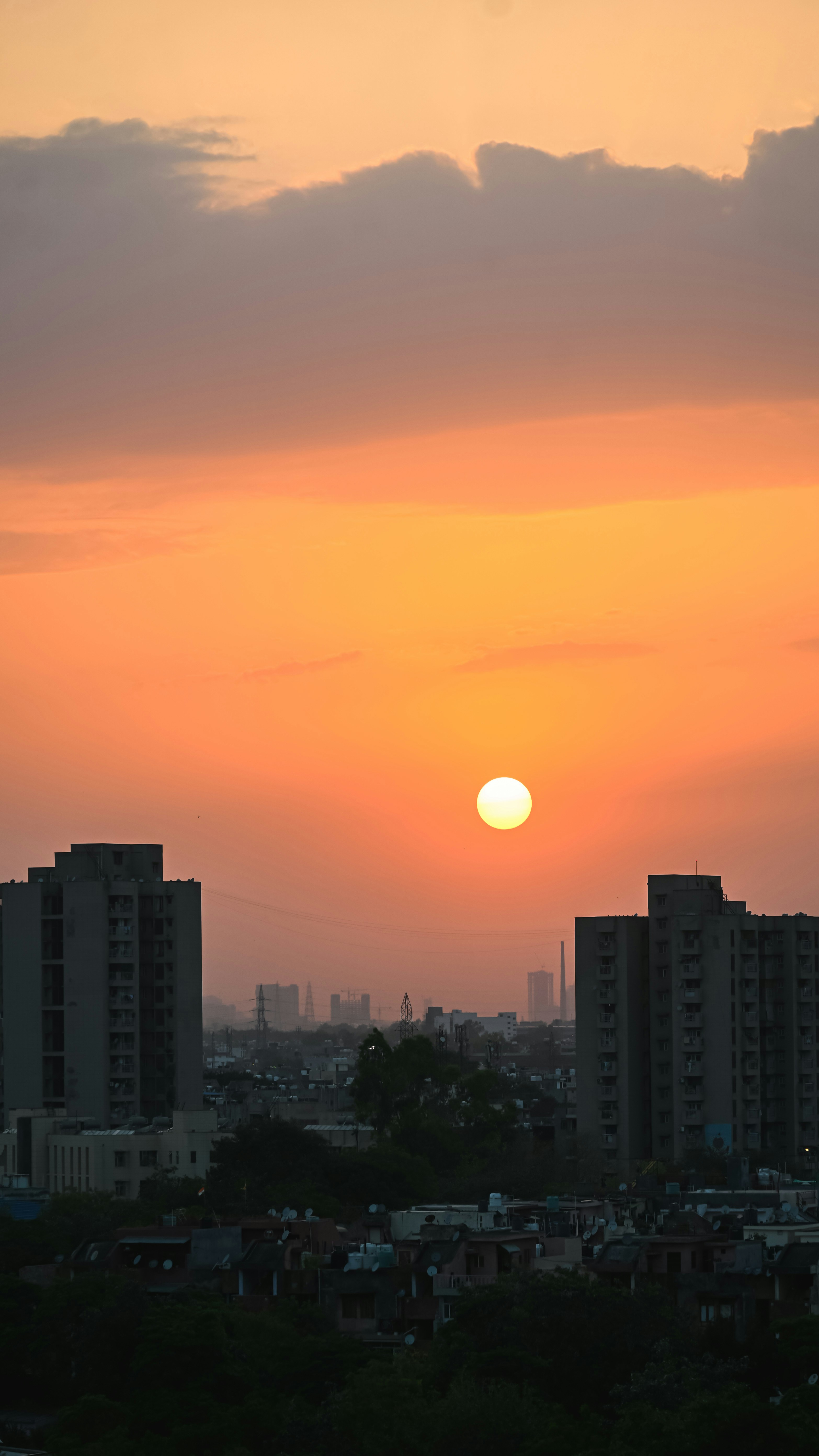 The sun is setting over a city with tall buildings photo – Free Urban ...
