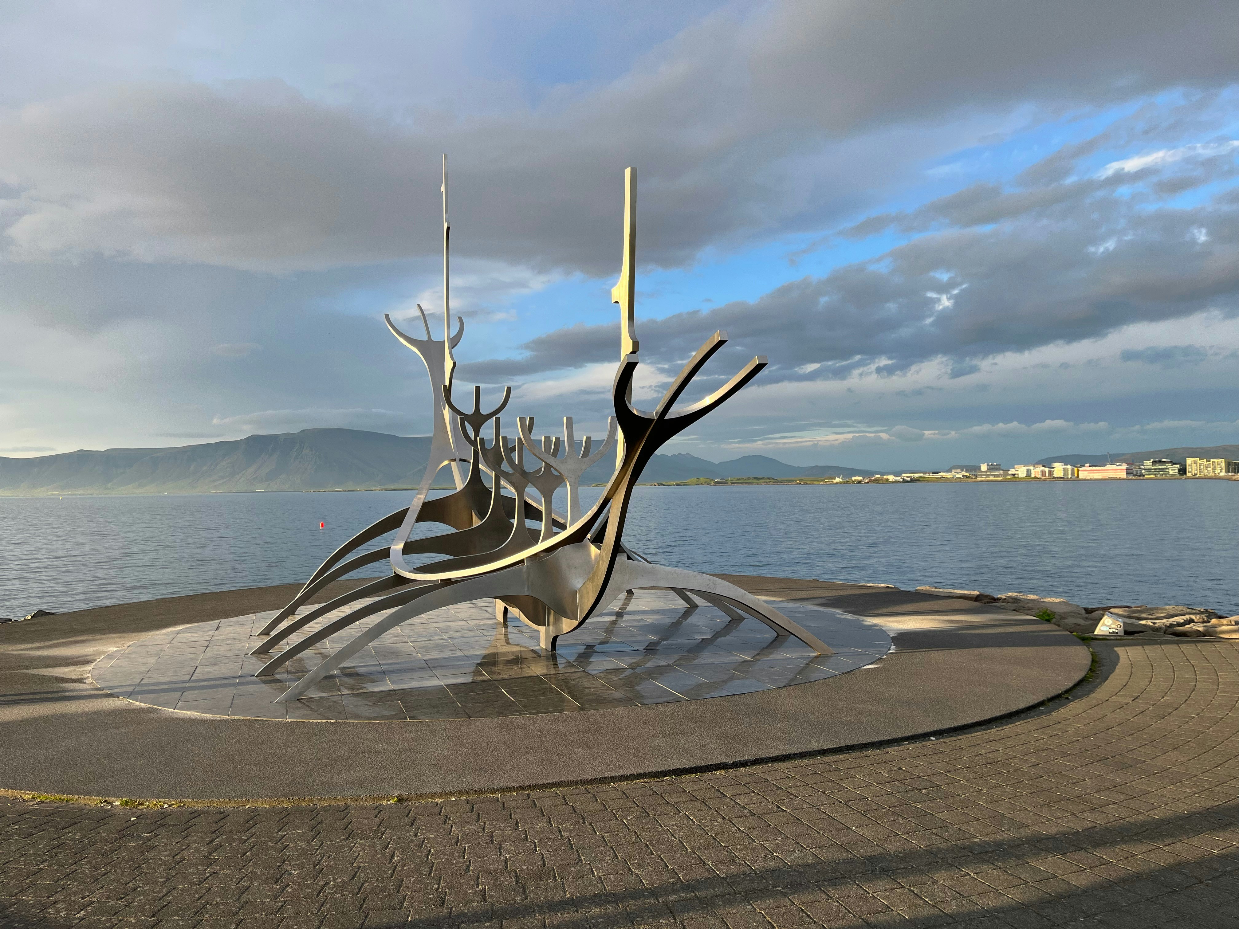 A large metal sculpture sitting in front of a body of water photo ...