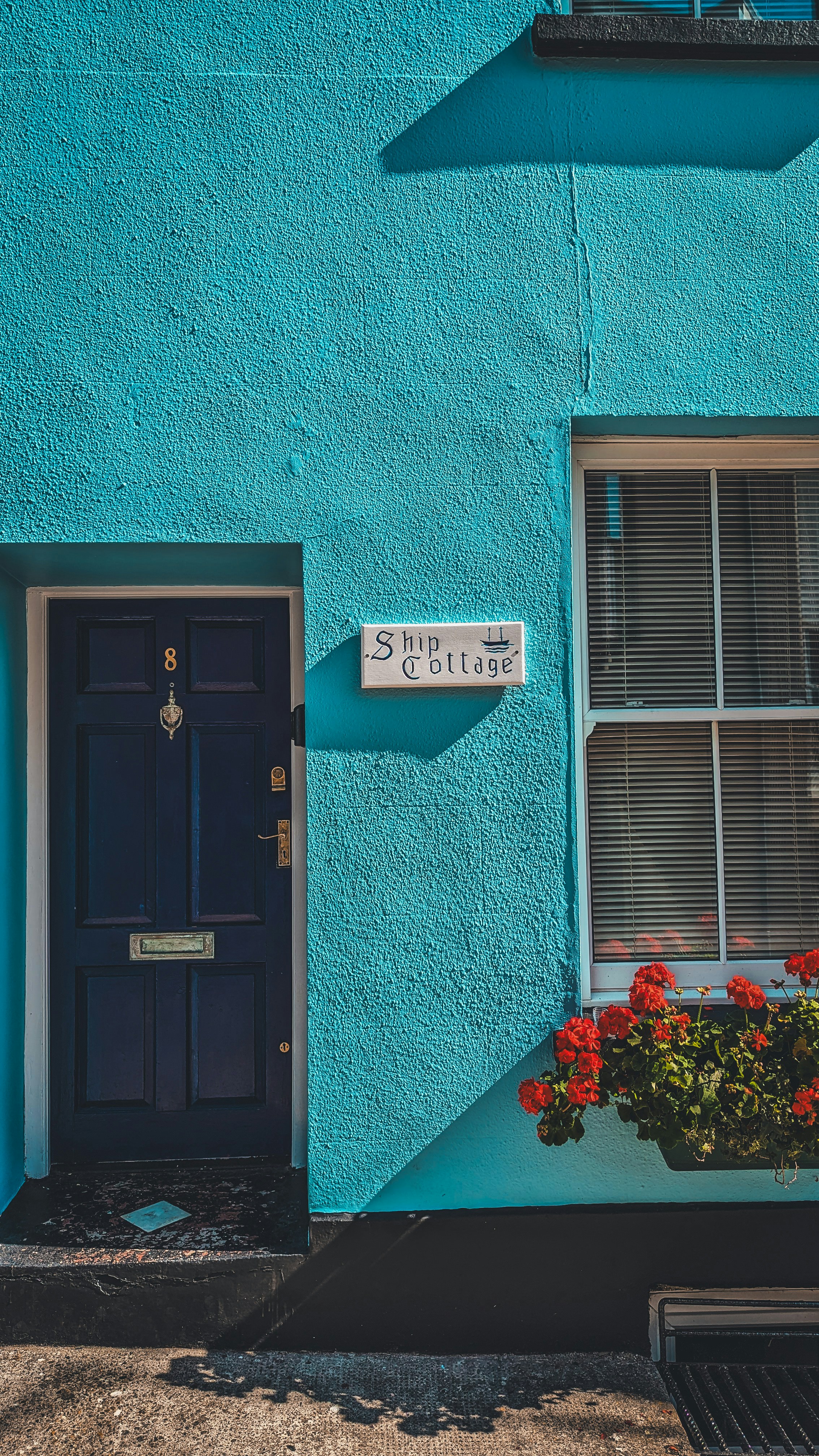 Ship Cottage: Teal Facade, Navy Door, and Crimson Window Box