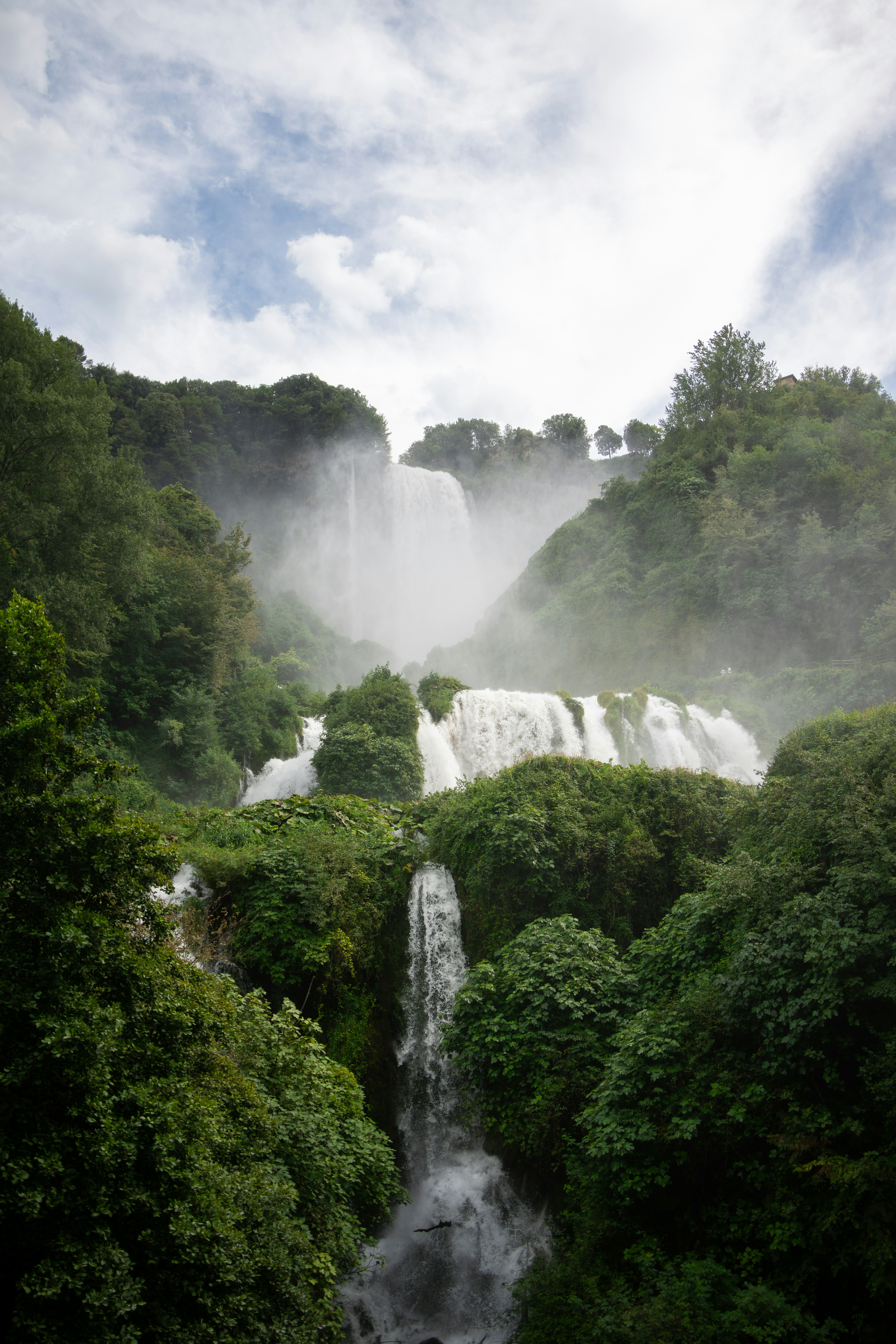 A waterfall in the middle of a lush green forest photo – Free Wallpaper ...
