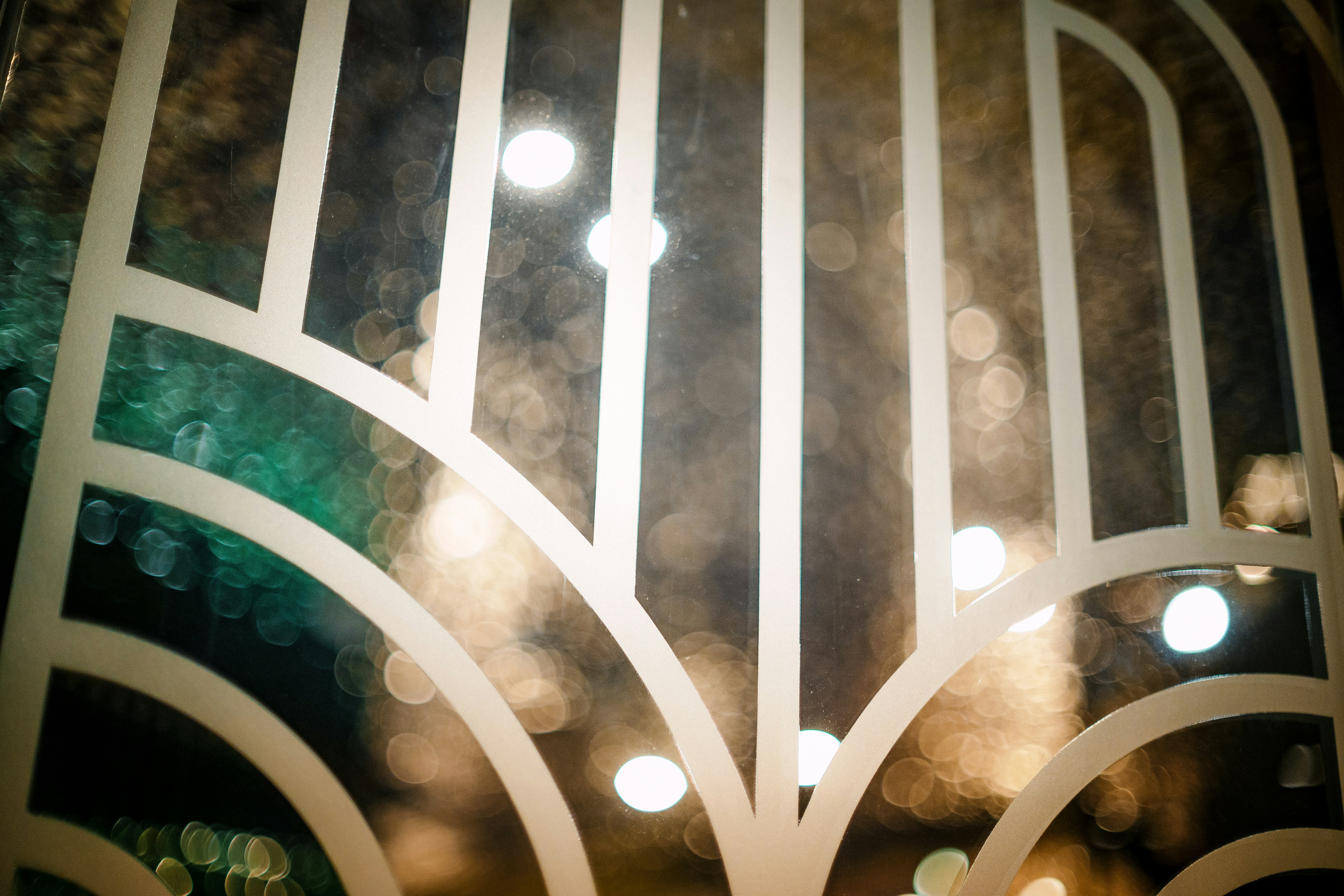 A close up of a metal gate with lights in the background photo – Free ...