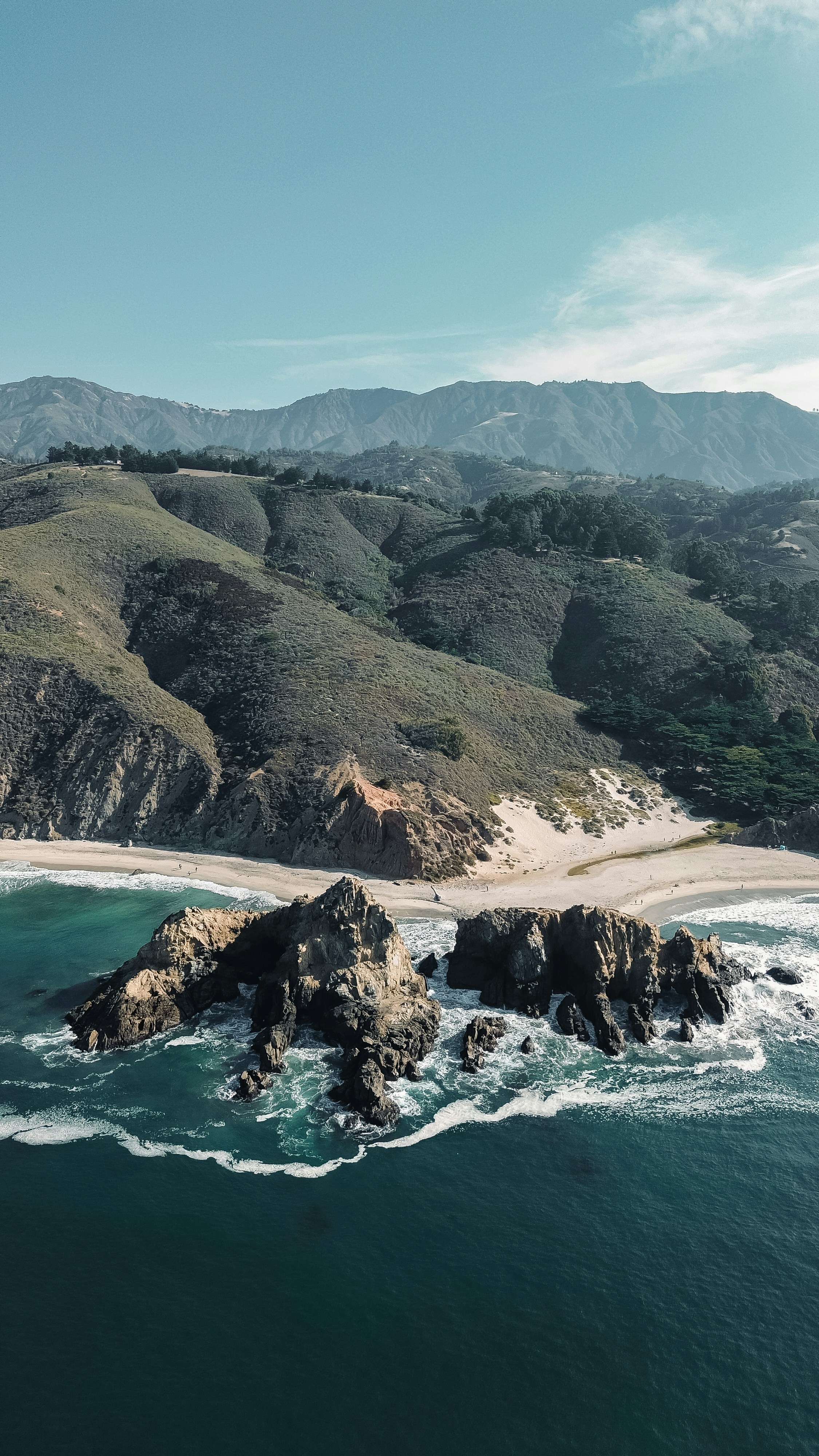 Rock Citadel Rising from Turquoise Swell: A Drone Coastline Panorama