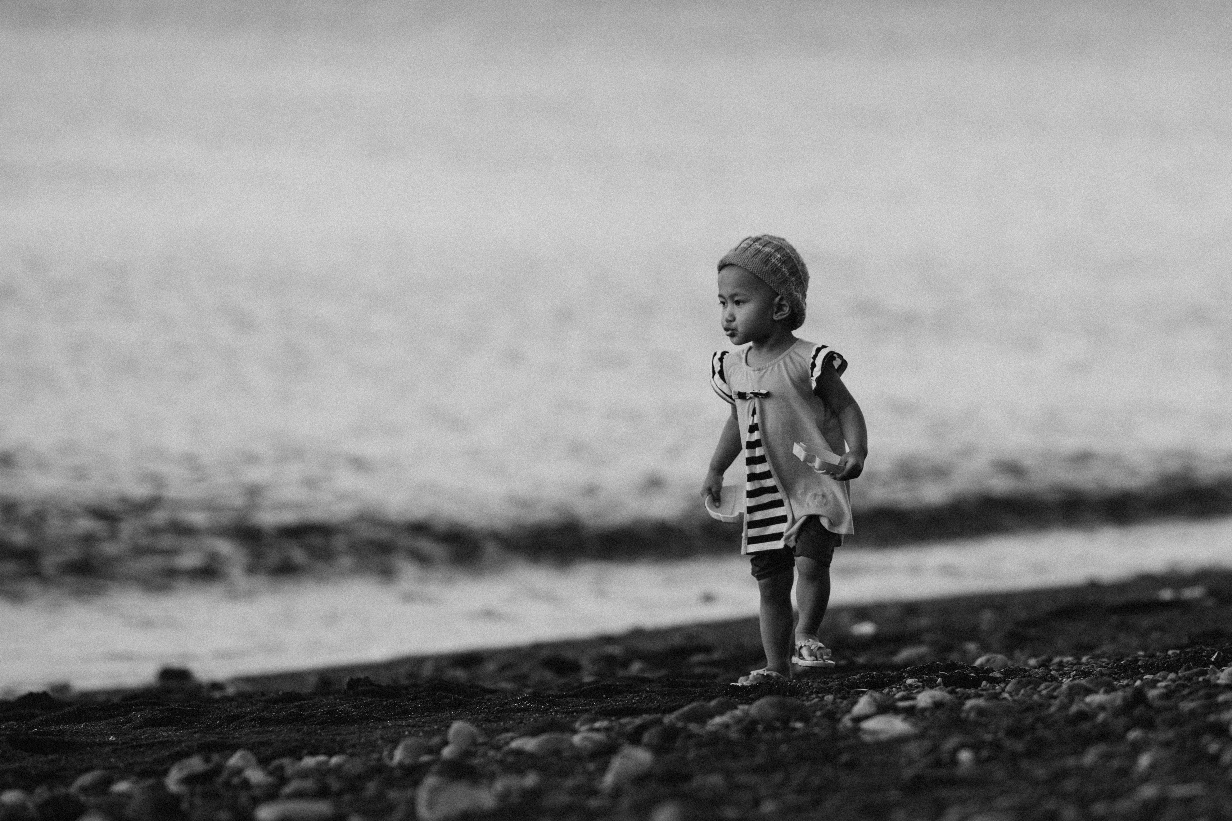 Pebble Steps at the Quiet Shore: A Striped-Girl Walks the Tide